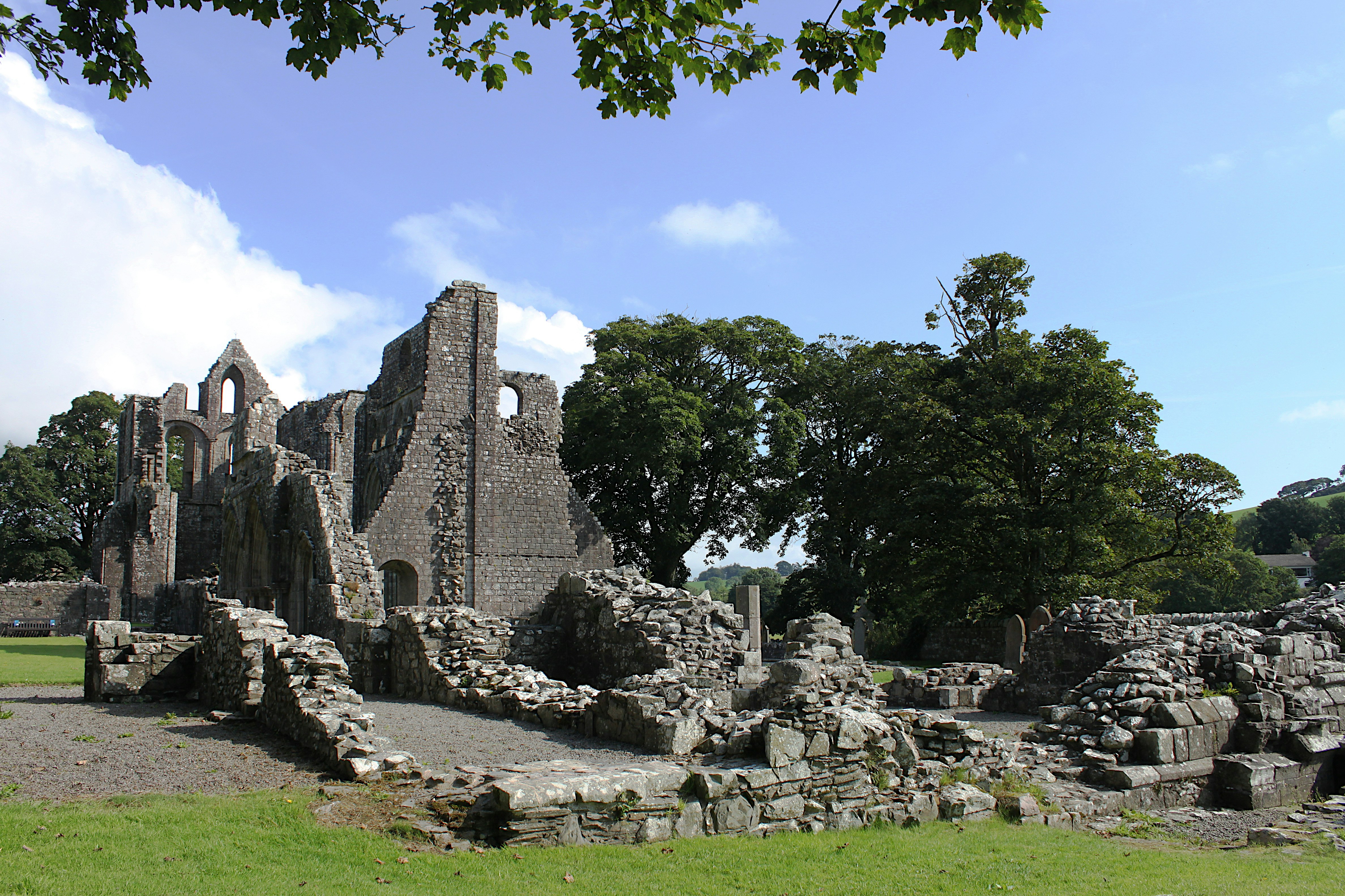 A large stone building sitting on top of a lush green field photo ...