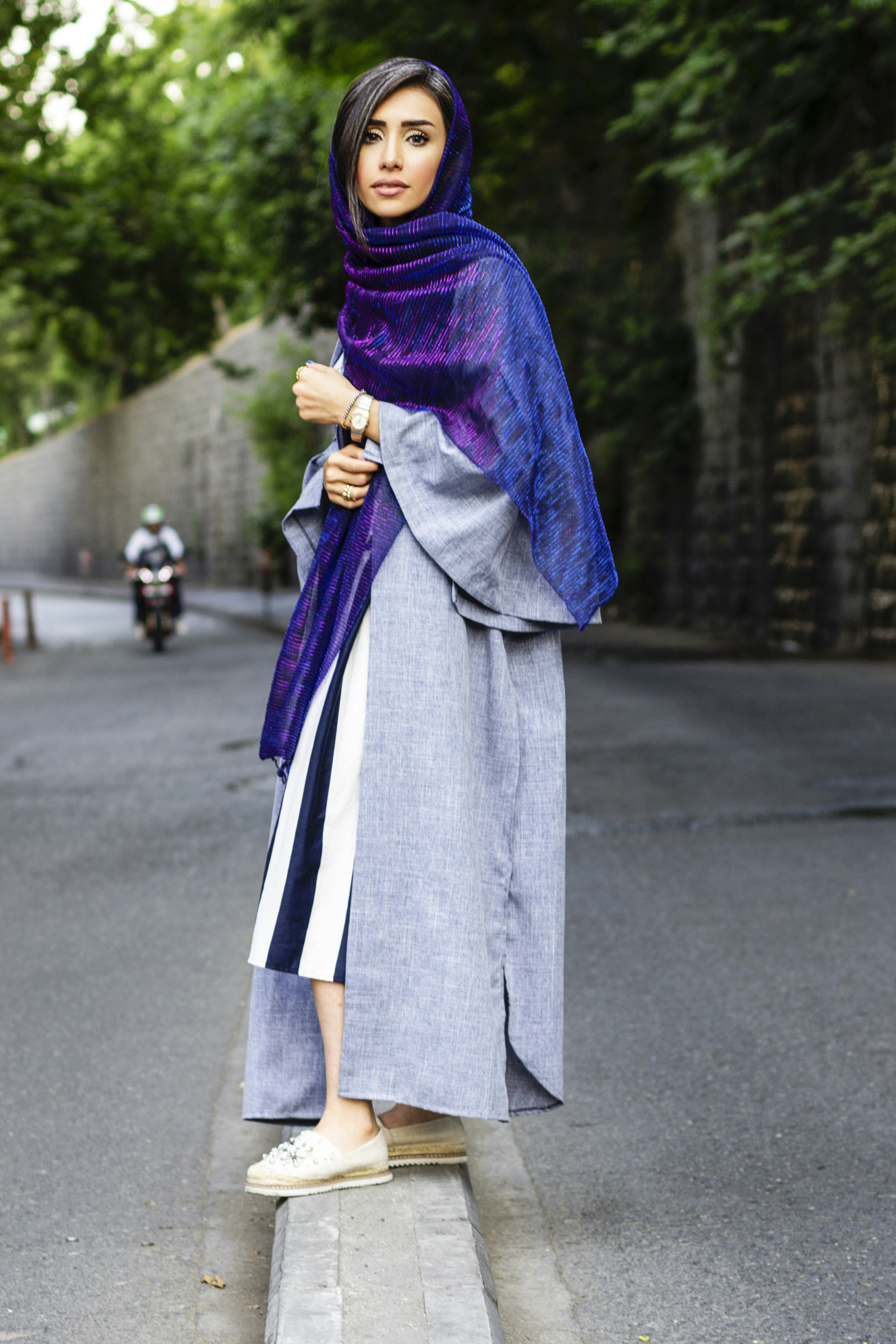 a woman standing on the side of a road