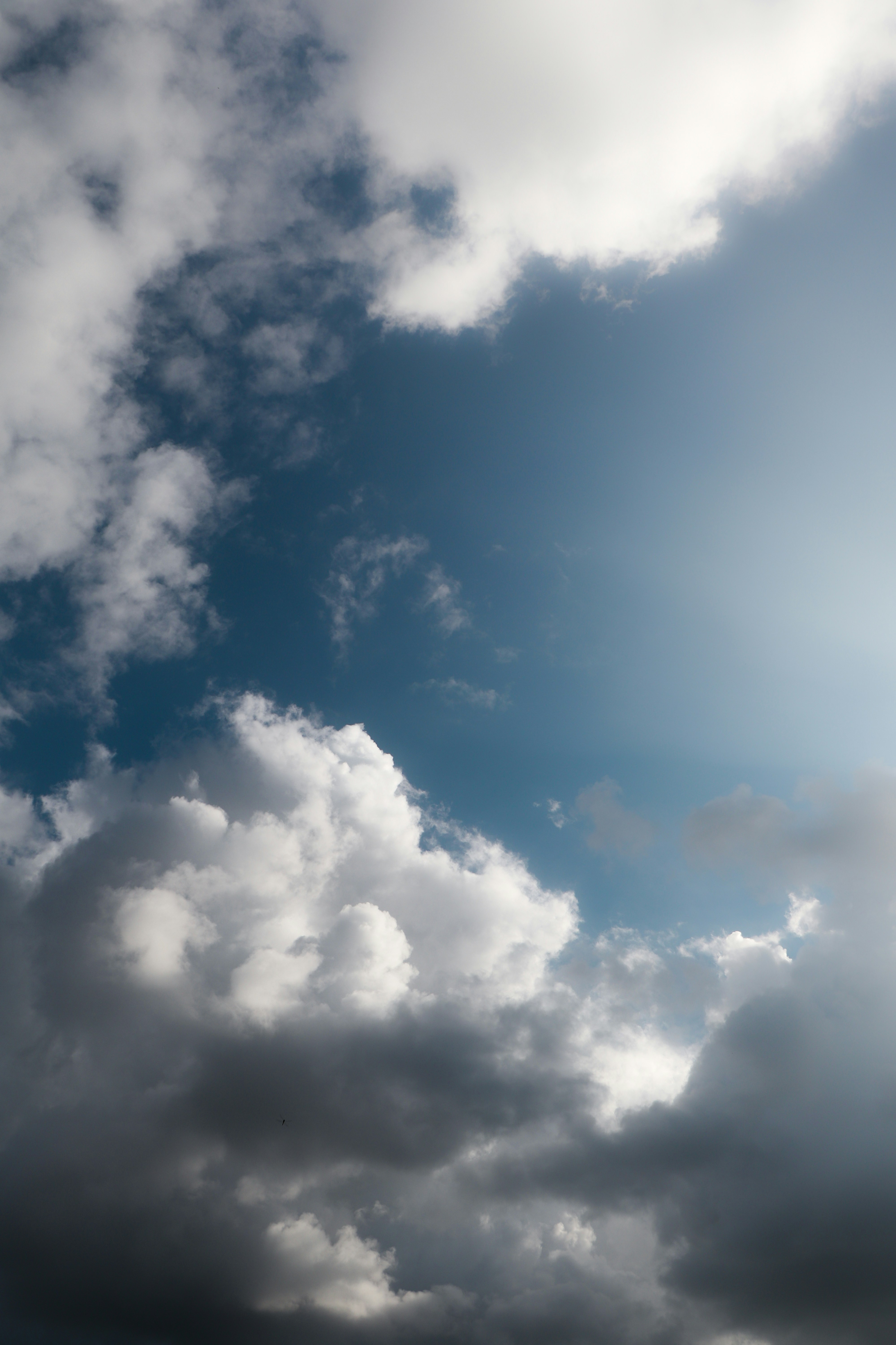 Un avión volando a través de un cielo azul nublado foto – Imagen de ...