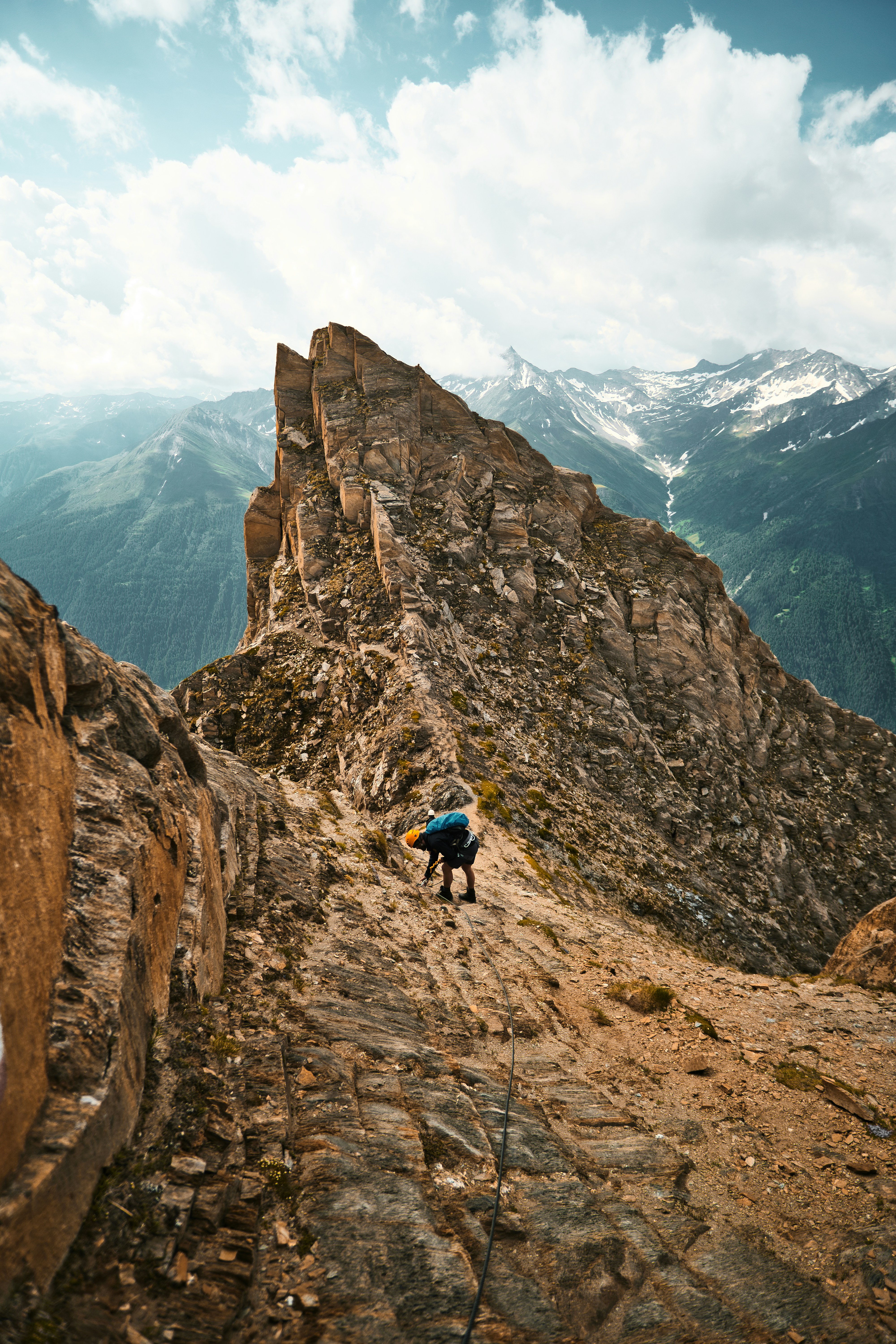 A person climbing up a mountain with a backpack photo – Free Rote säule ...
