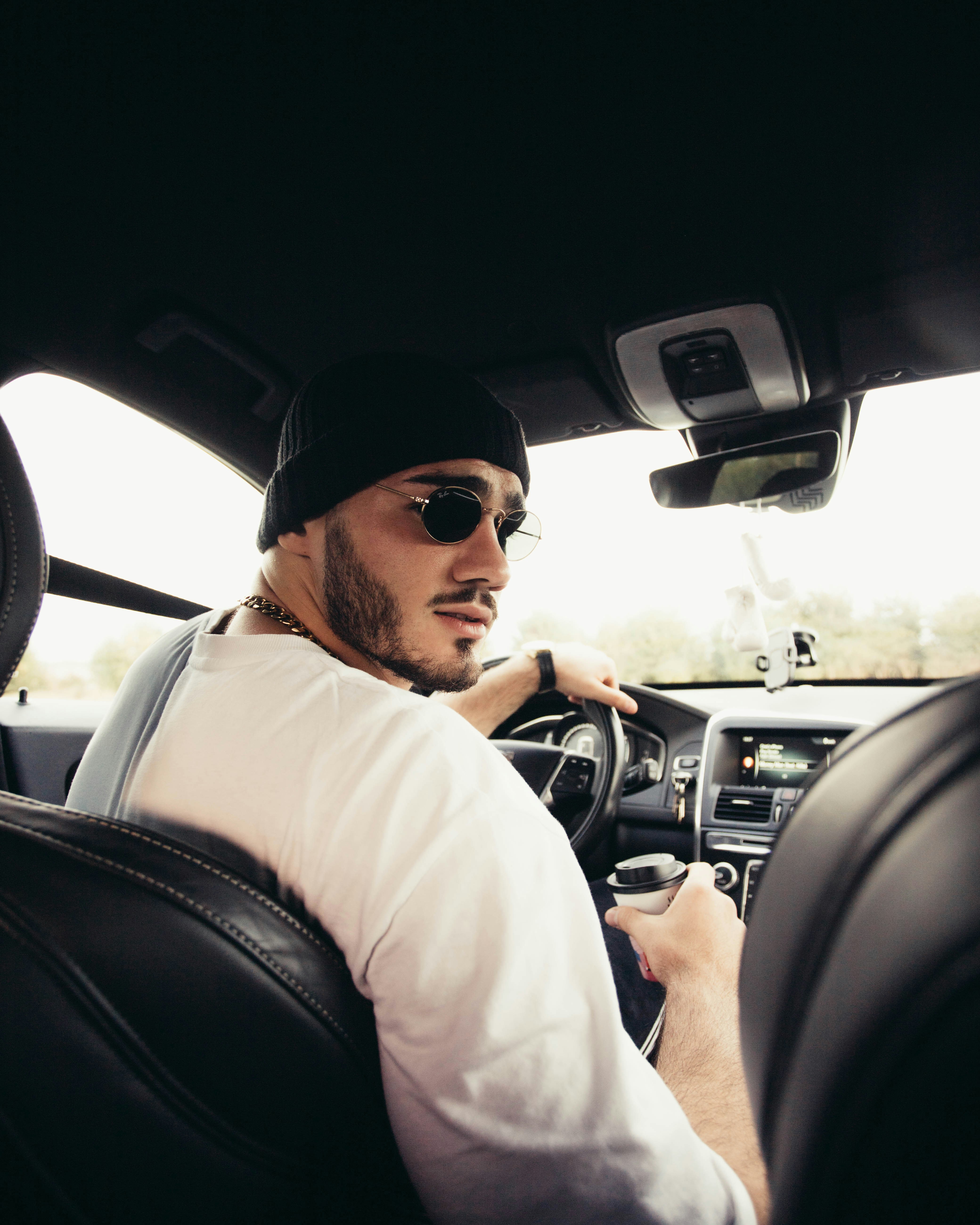 A man driving a car wearing sunglasses and a beanie photo – Free ...
