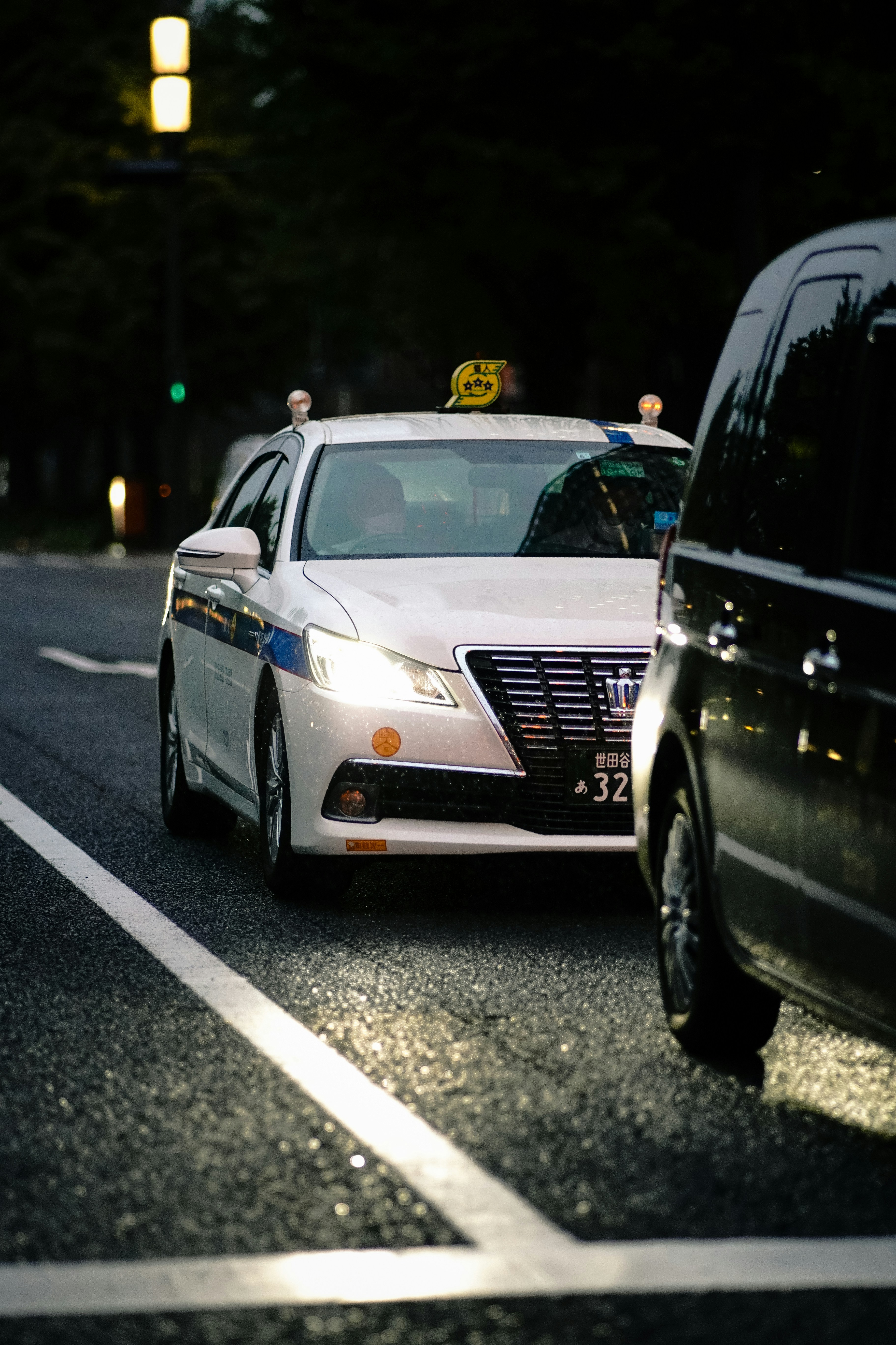 A police car driving down a street next to a van photo – Free Tōkyō ...