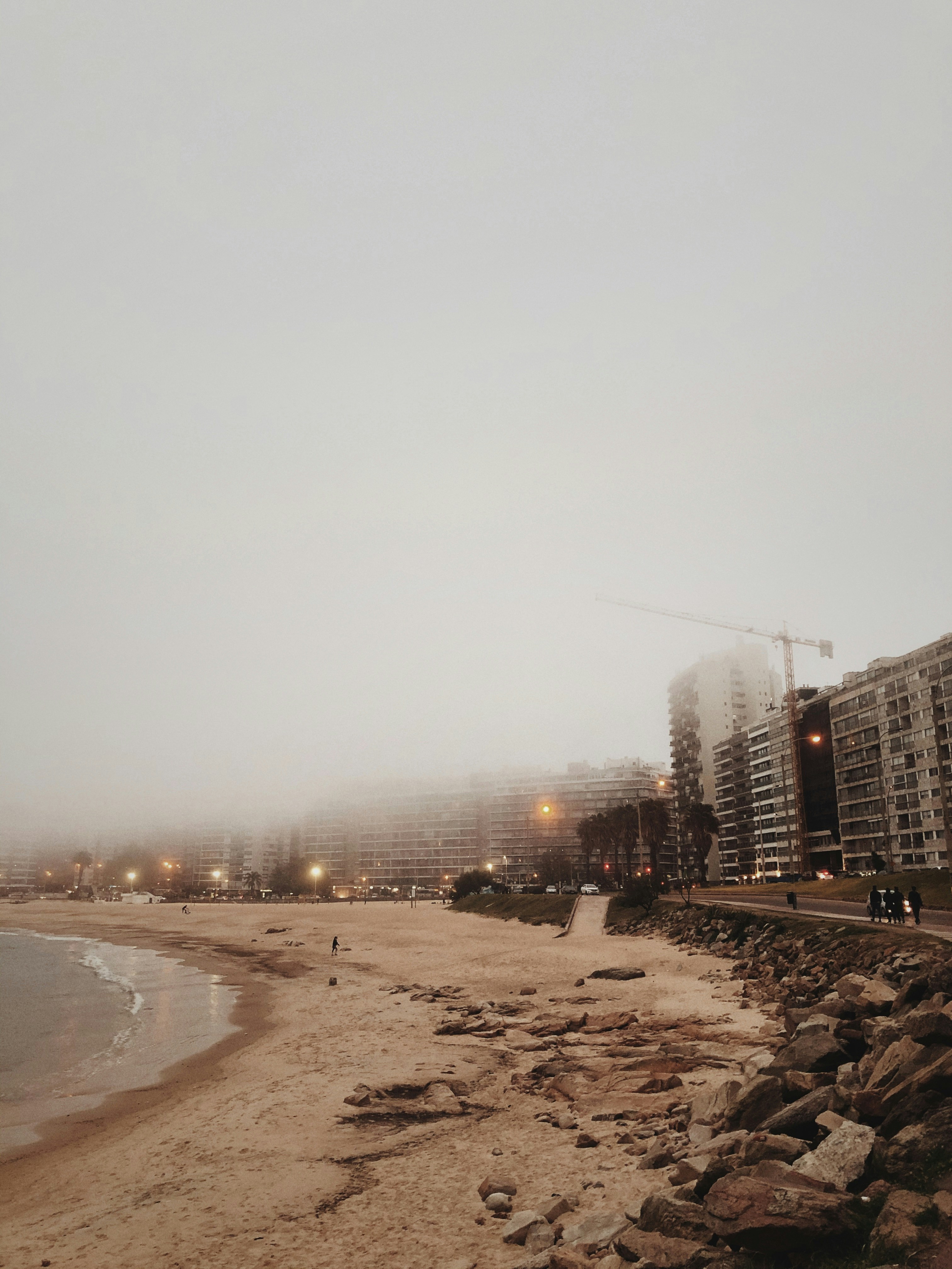 a foggy day at the beach with a few people