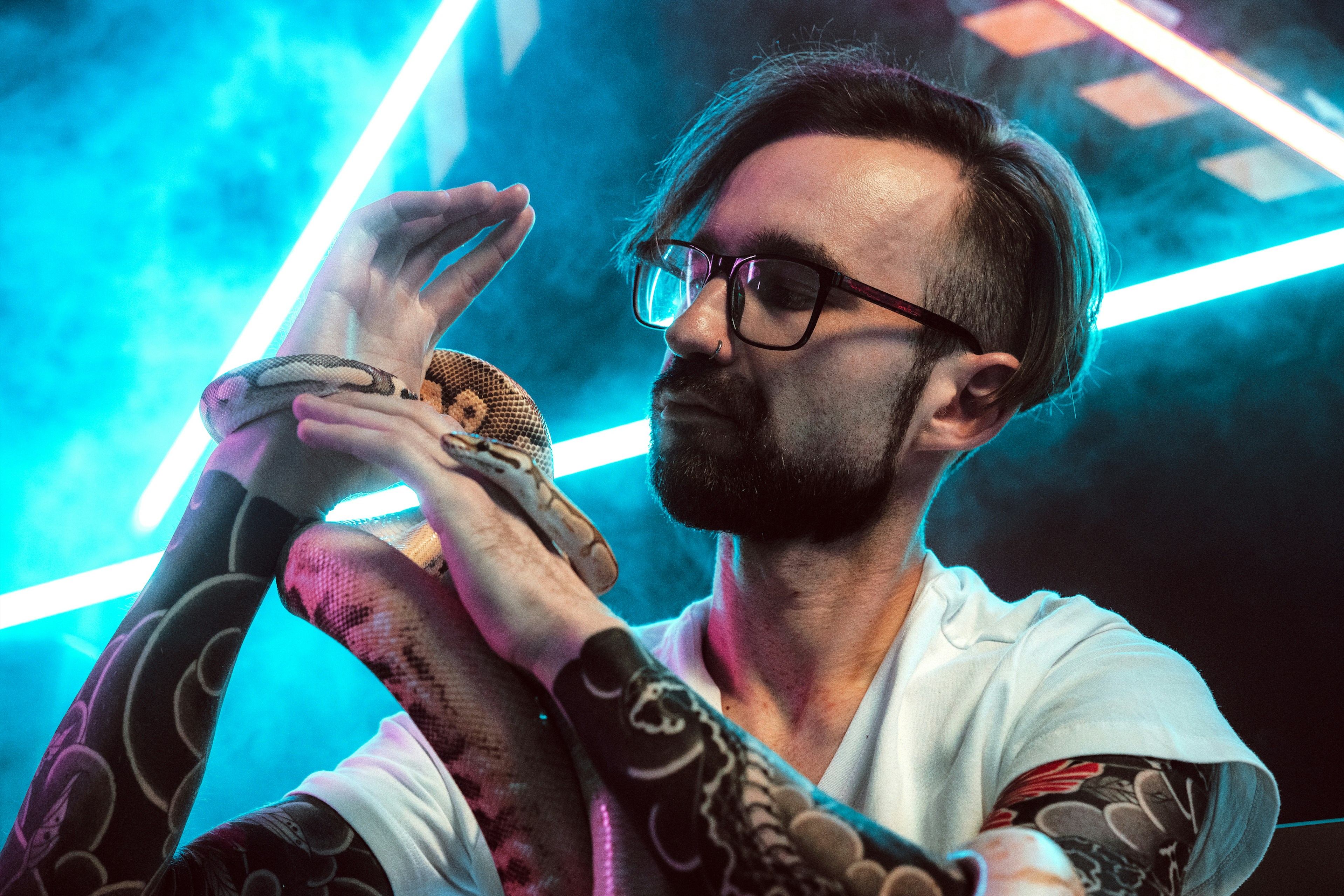 Neon Flux and the Serpent: Portrait of a Tattooed Performer Under Blue Geometric Light