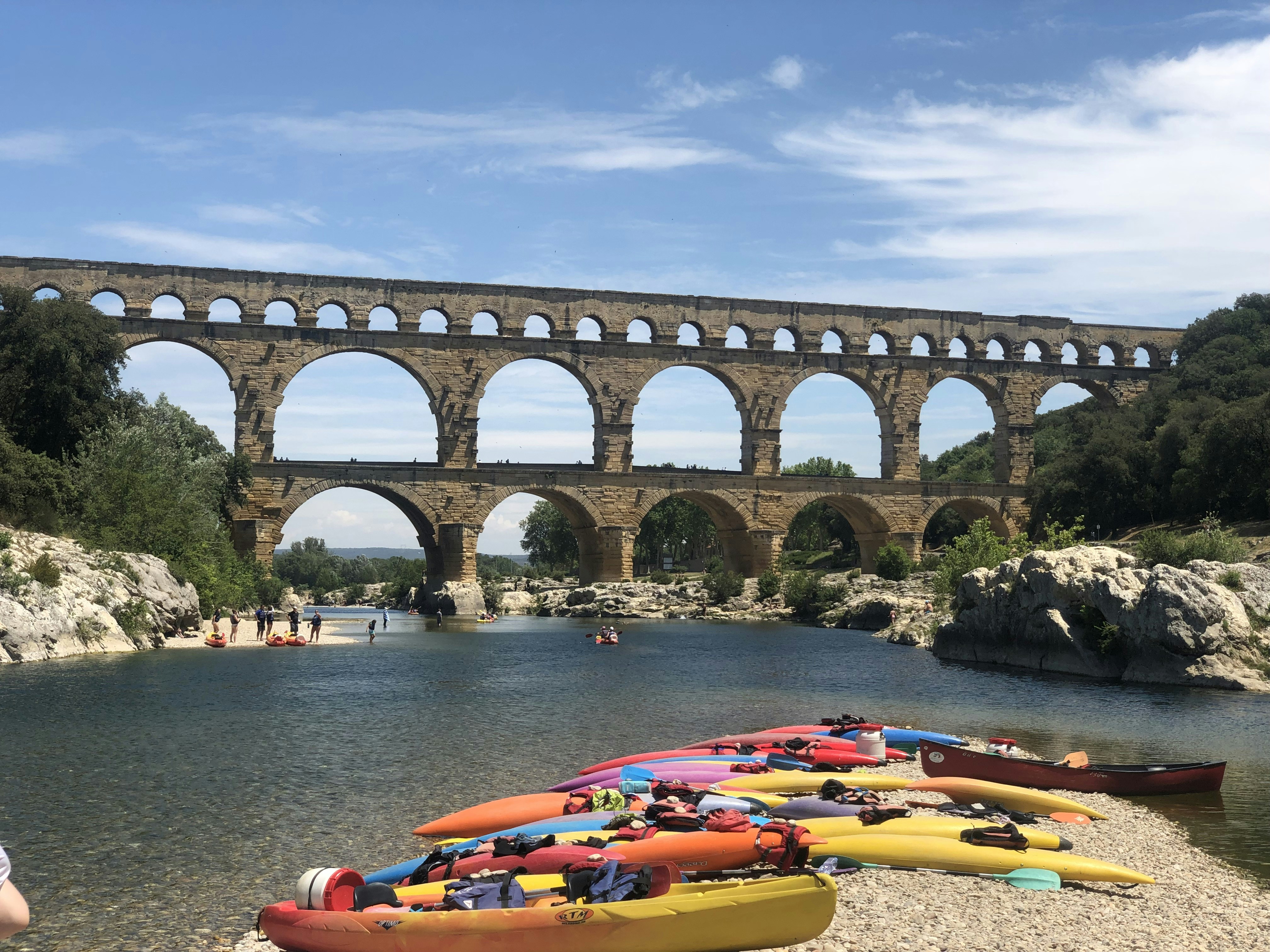 Riverside Echoes: Kayaks at the Foot of an Ancient Aqueduct