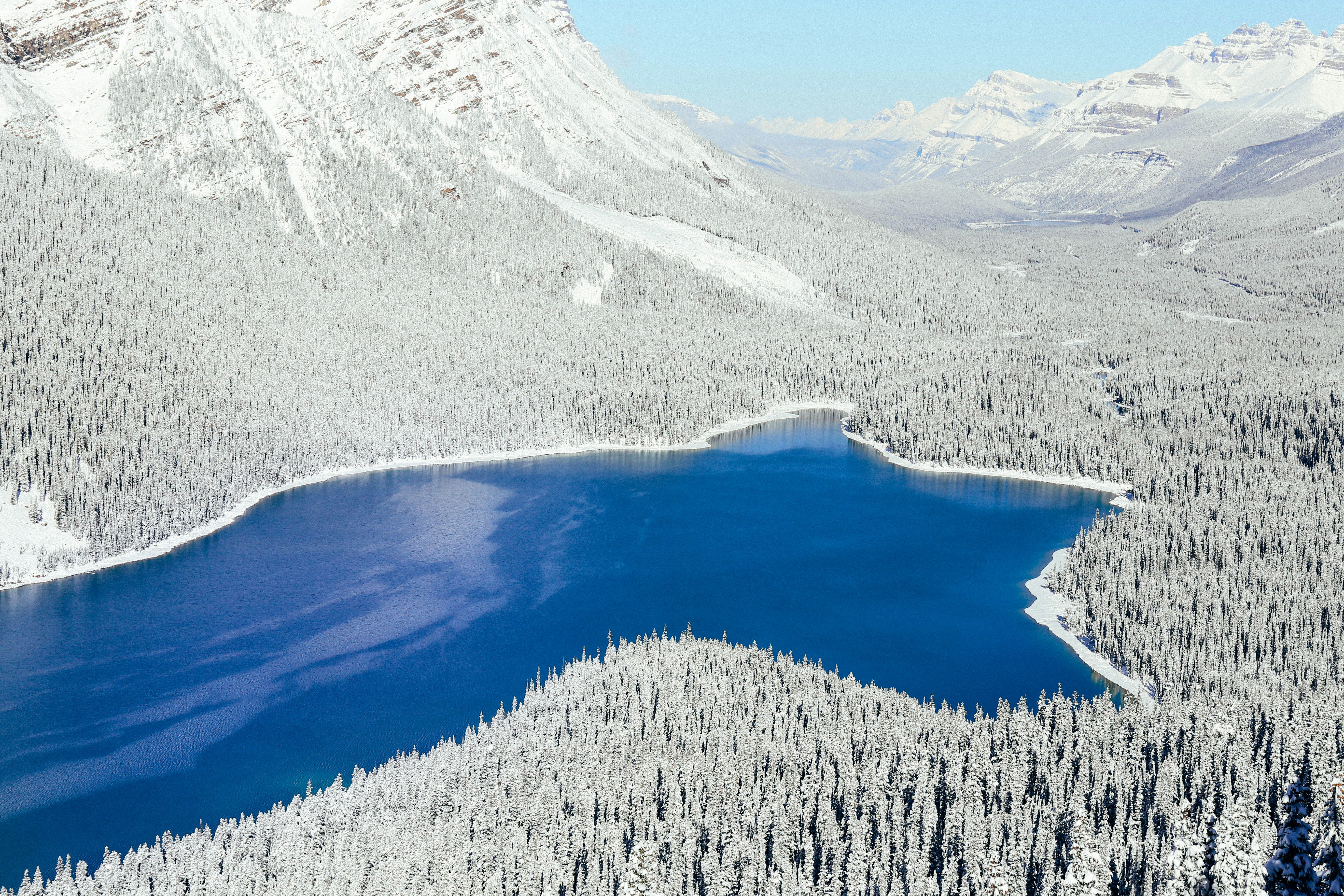 A large blue lake surrounded by snow covered mountains photo – Free ...