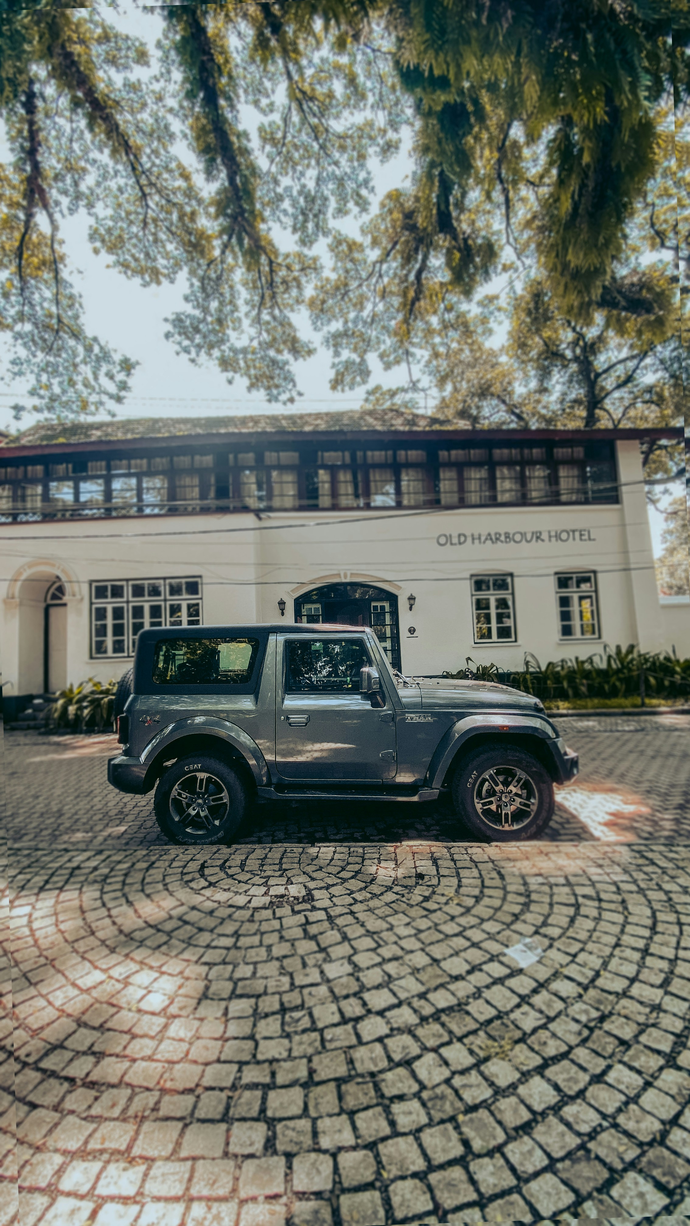 a gray jeep parked in front of a white building