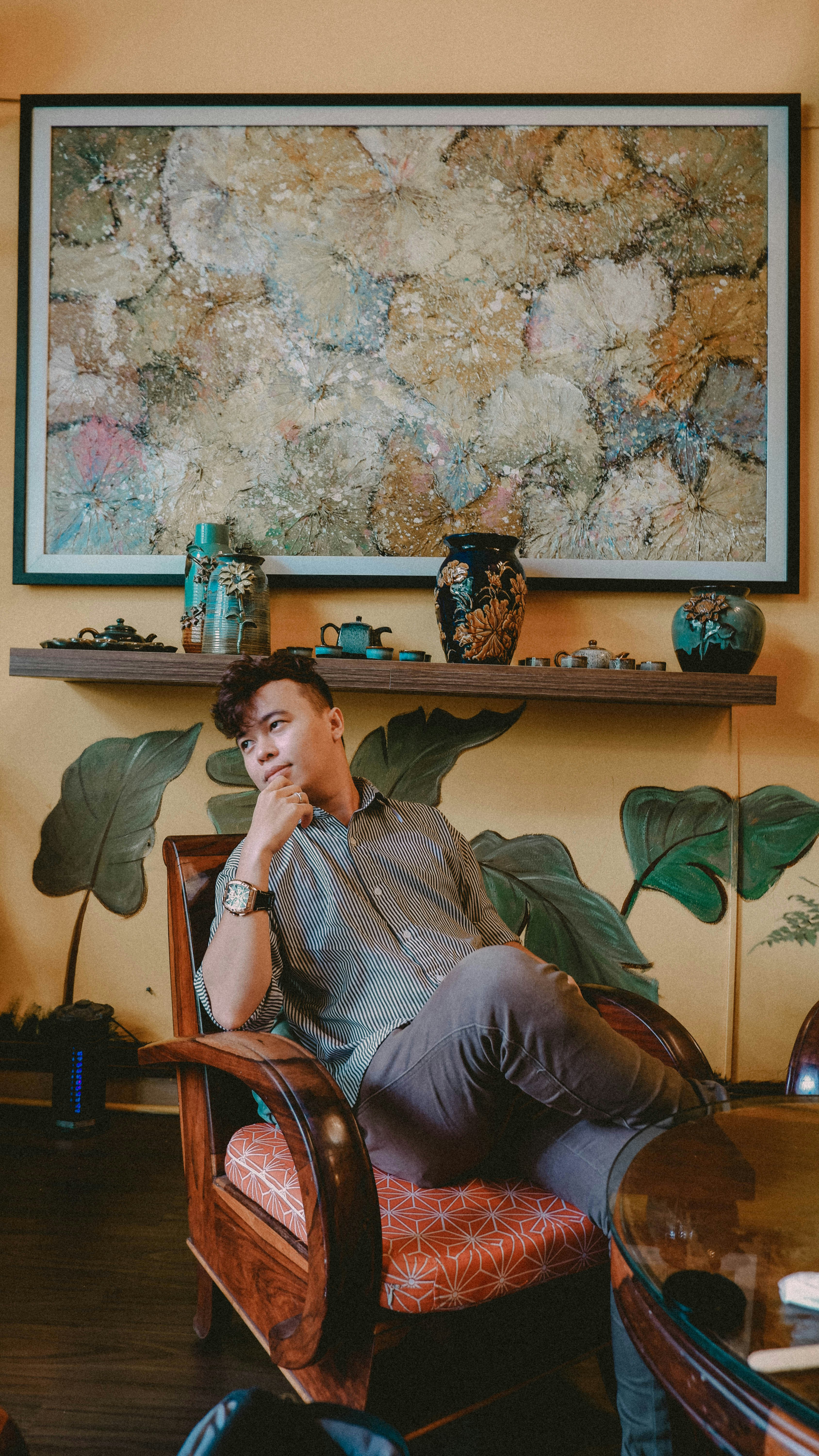 Un homme assis sur une chaise devant un tableau photo – Photo Meubles ...