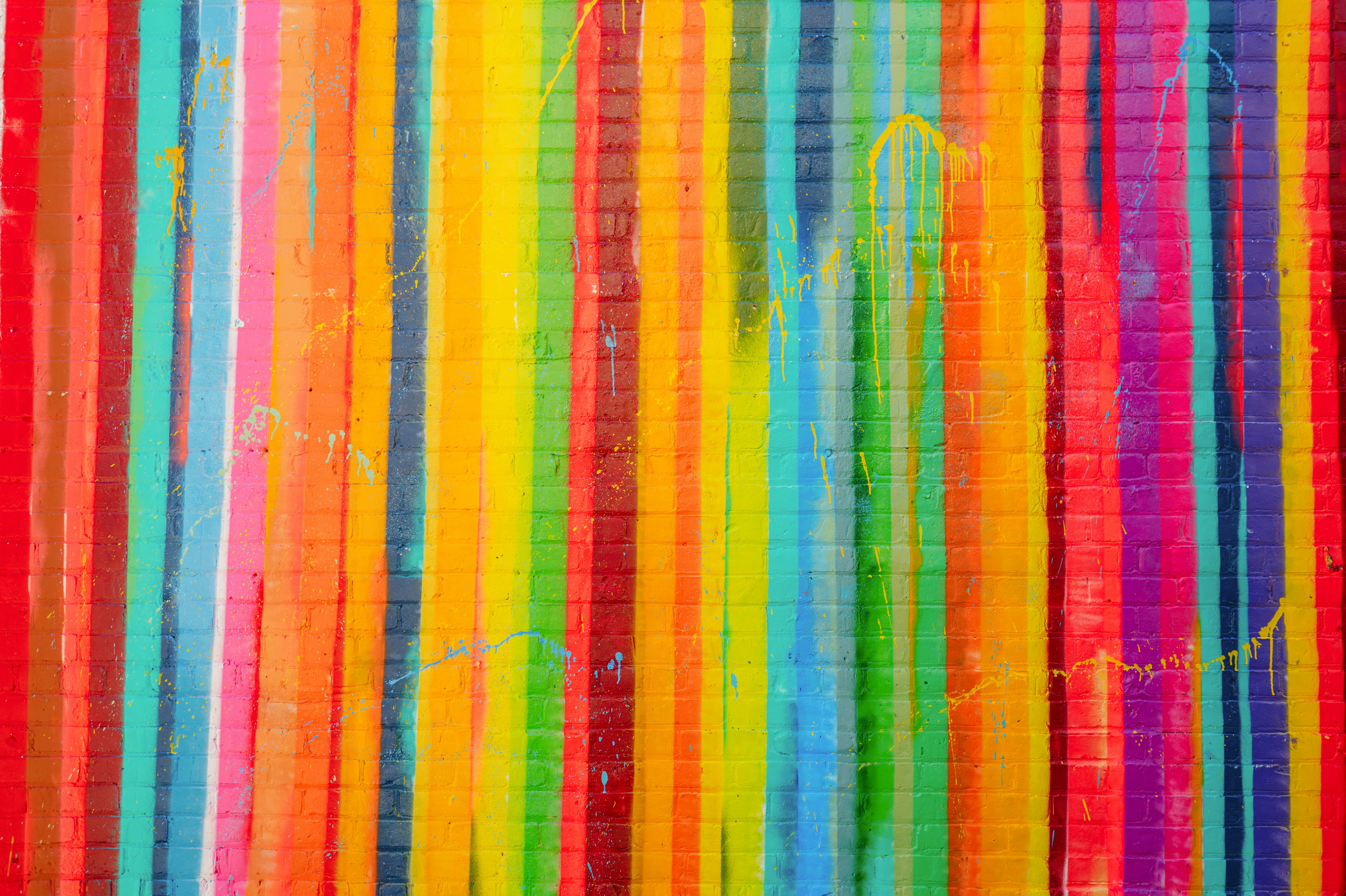 Una pared de ladrillo multicolor con líneas verticales pintadas en ella ...