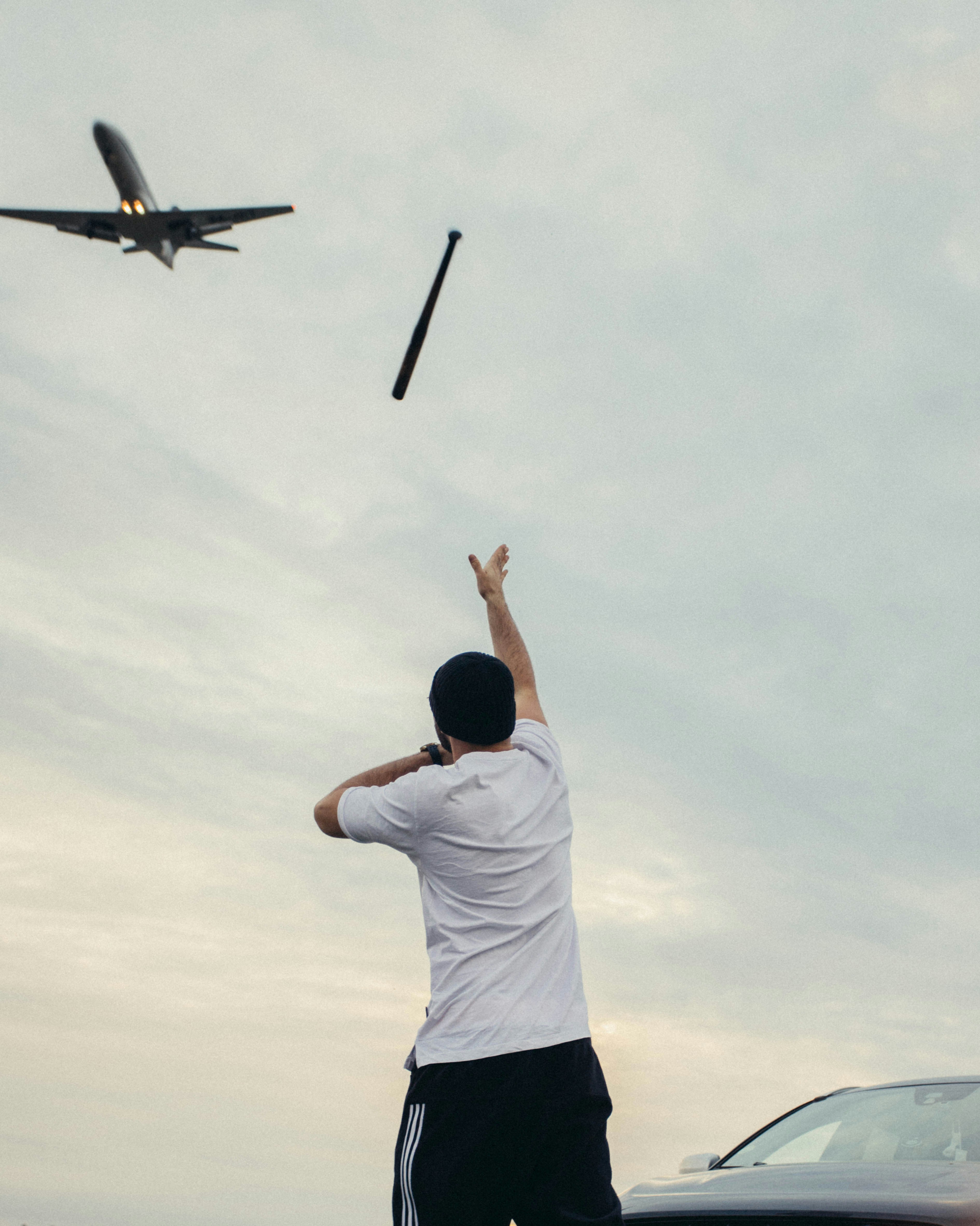 Airborne Moment: A Baton Leaps as a Plane Approaches