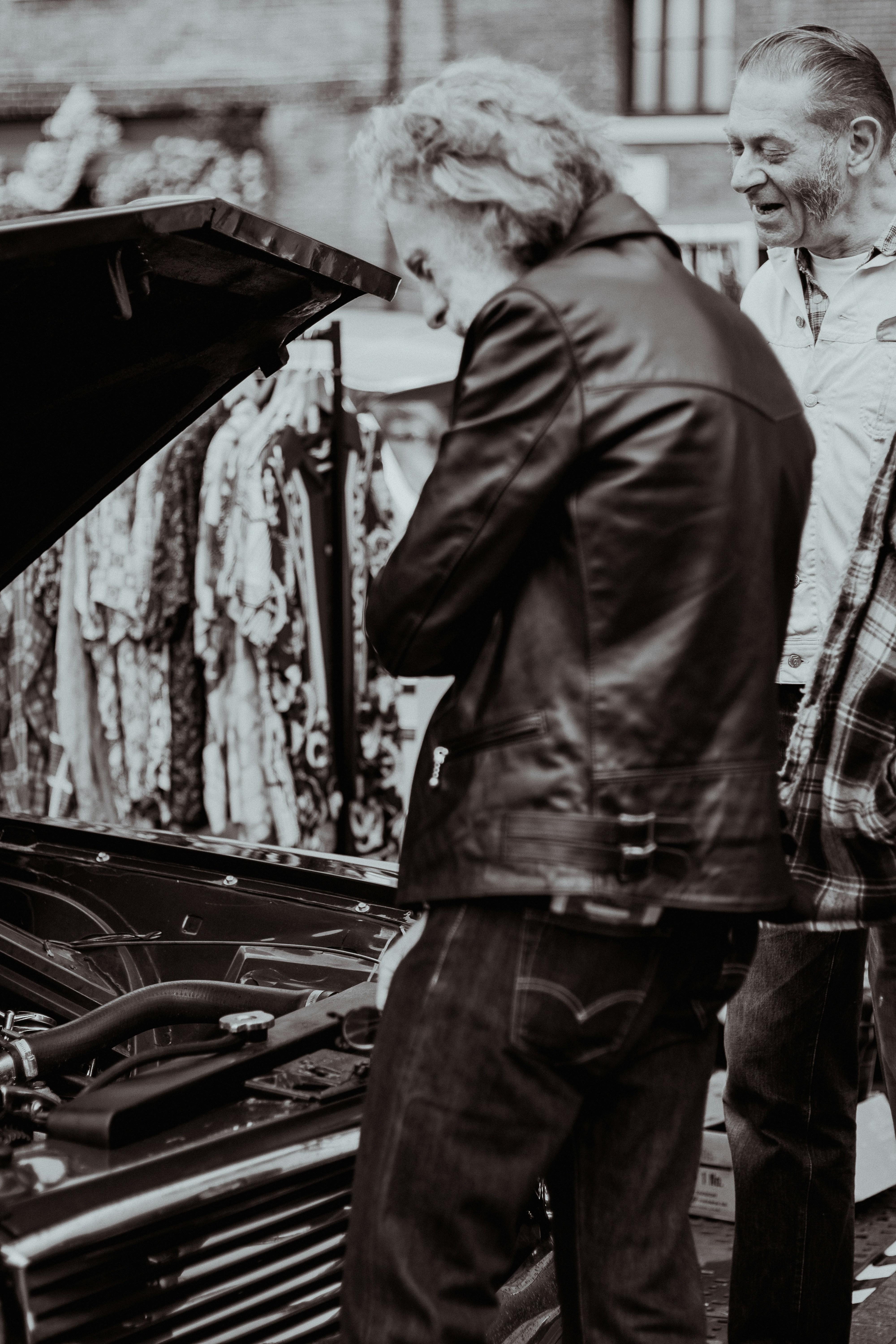 Two Men at a Classic Car Show: Engine Hood Lift and Conversation