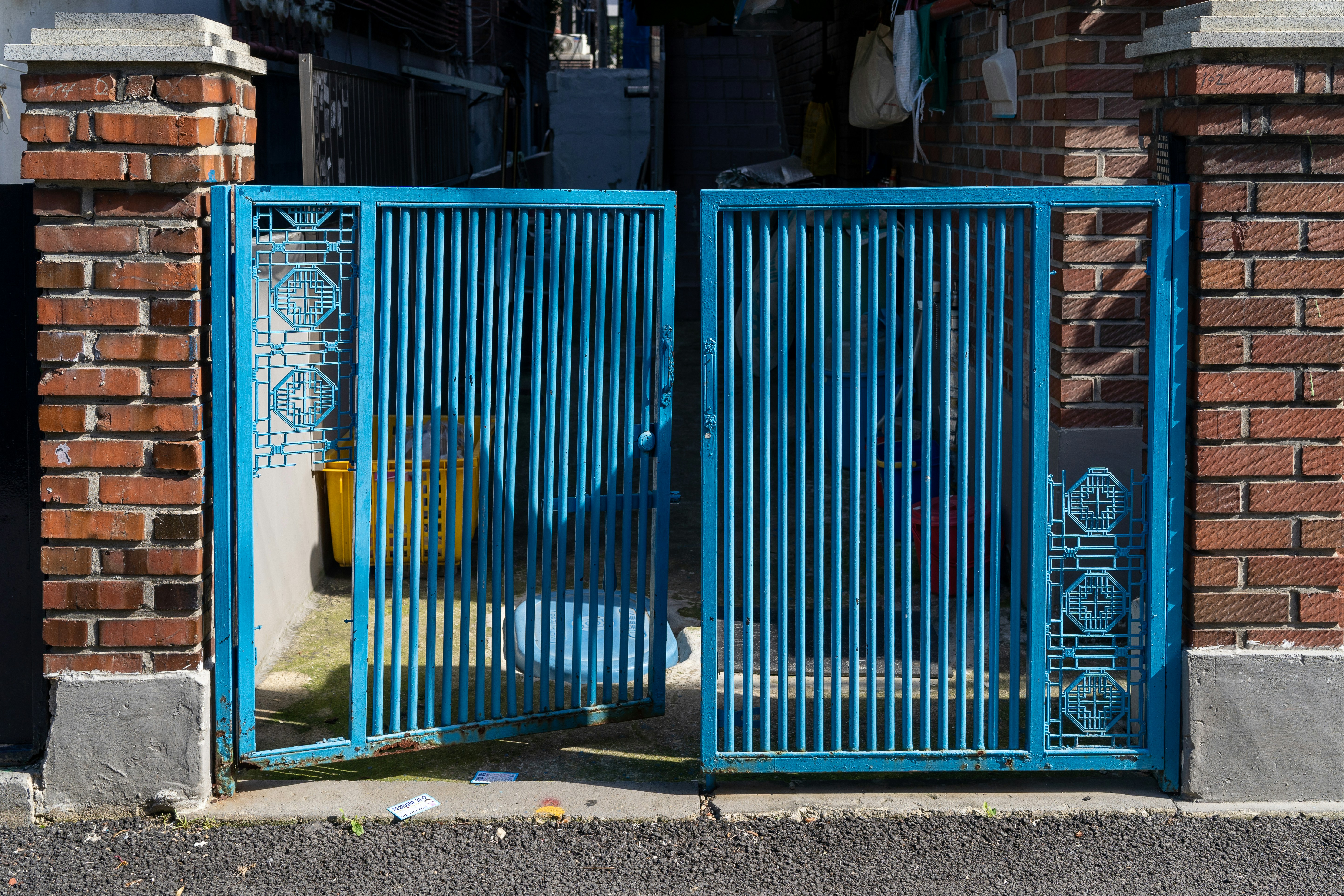 A couple of blue gates that are on the side of a building photo – Free ...