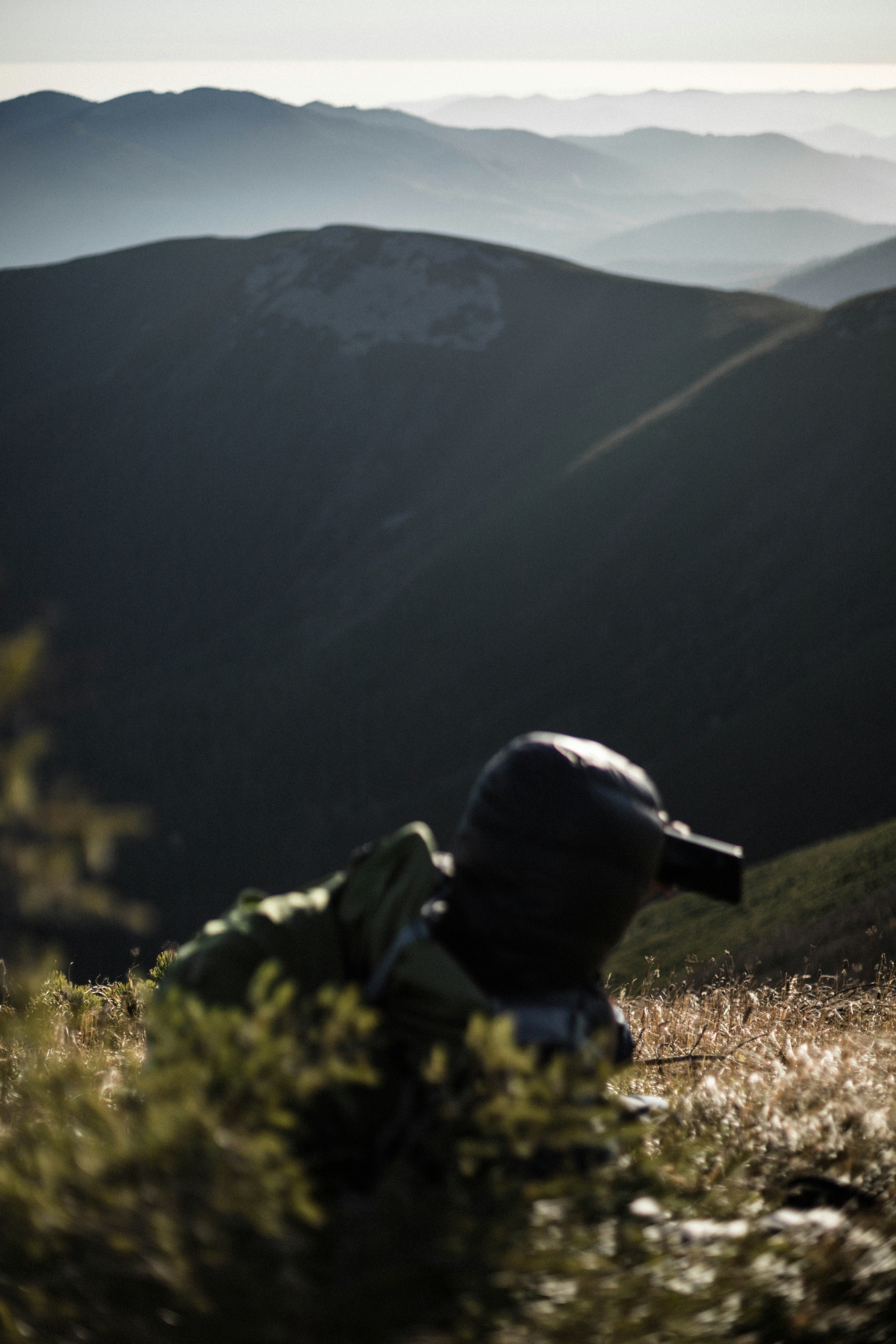 Foto Una persona sentada en una colina con montañas en el fondo ...