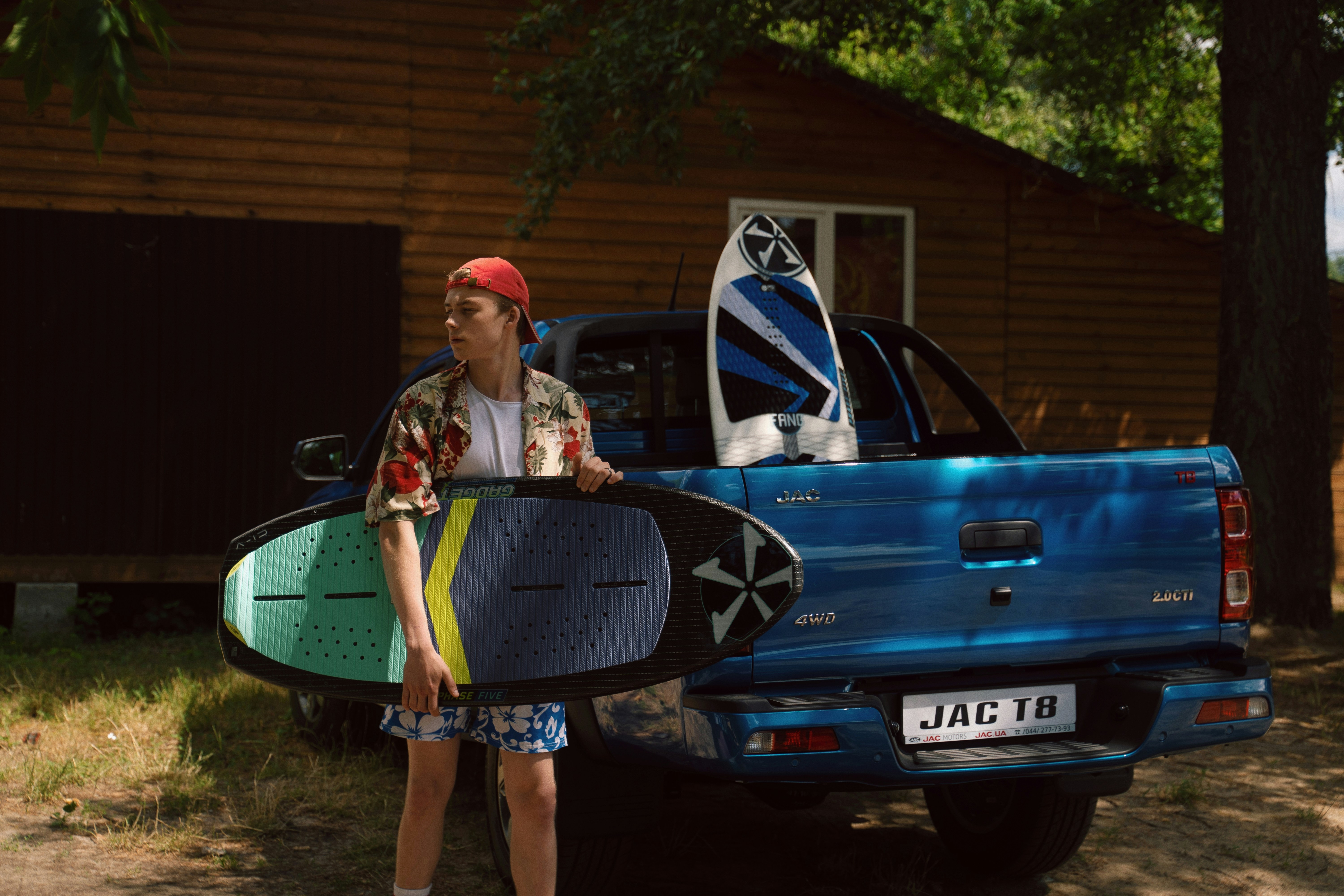 Surfboarder by the Blue Truck: A Summer Moment in the Pines