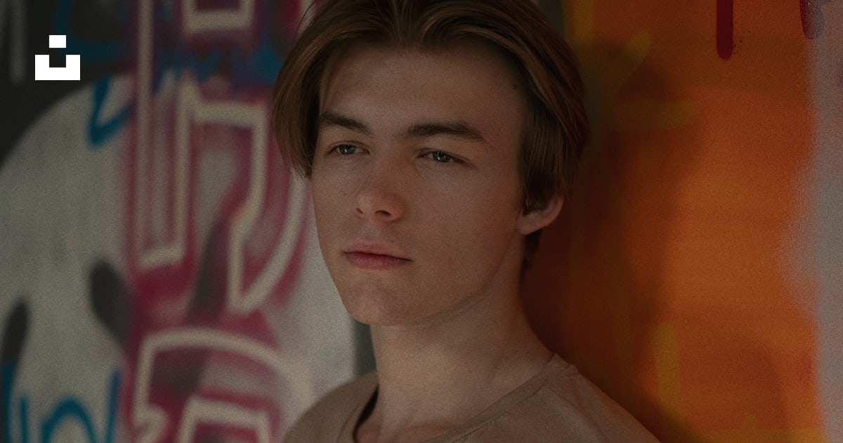 Un Jeune Homme Debout Devant Un Mur Couvert De Graffitis Photo Photo