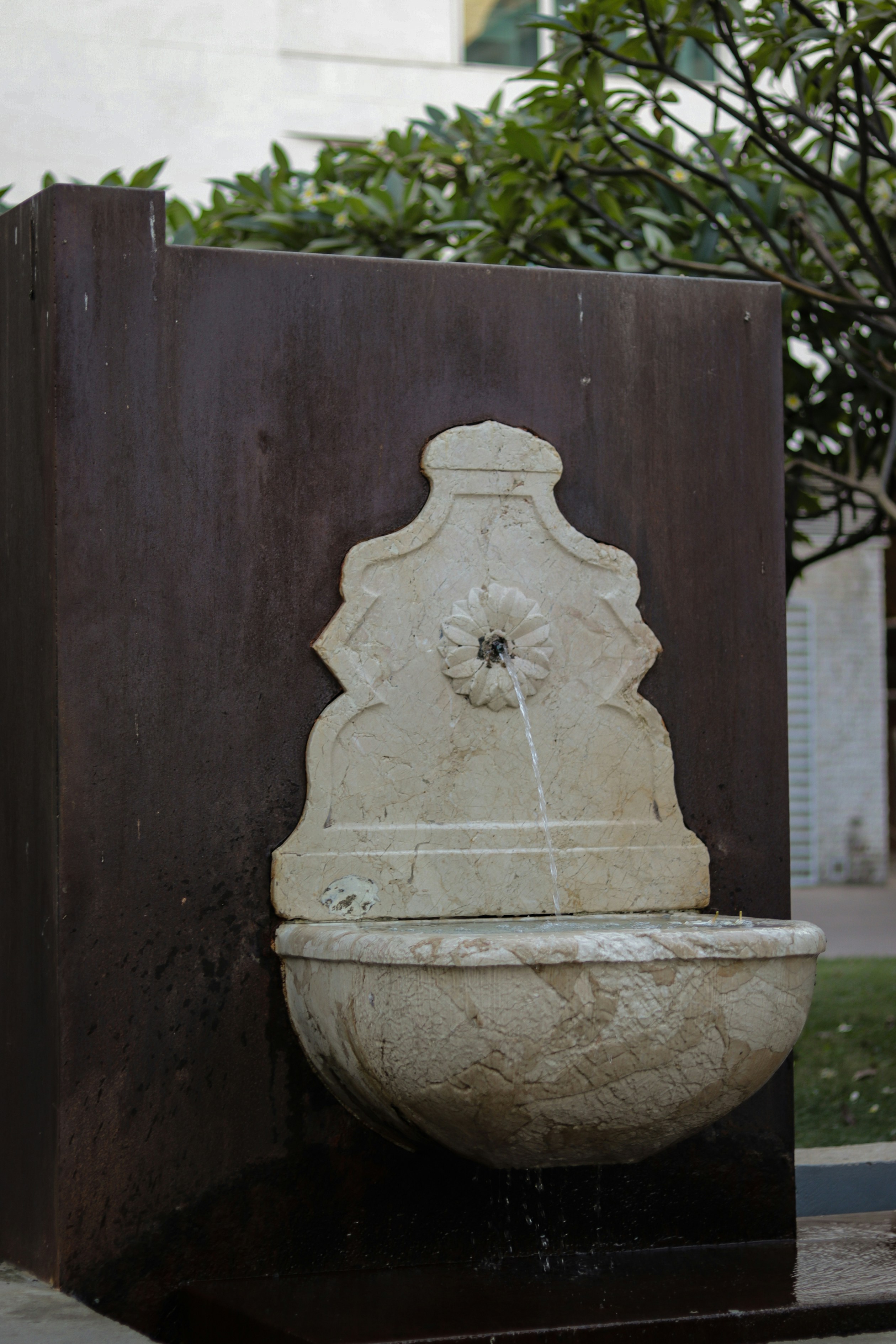 a white water fountain sitting on top of a wooden stand