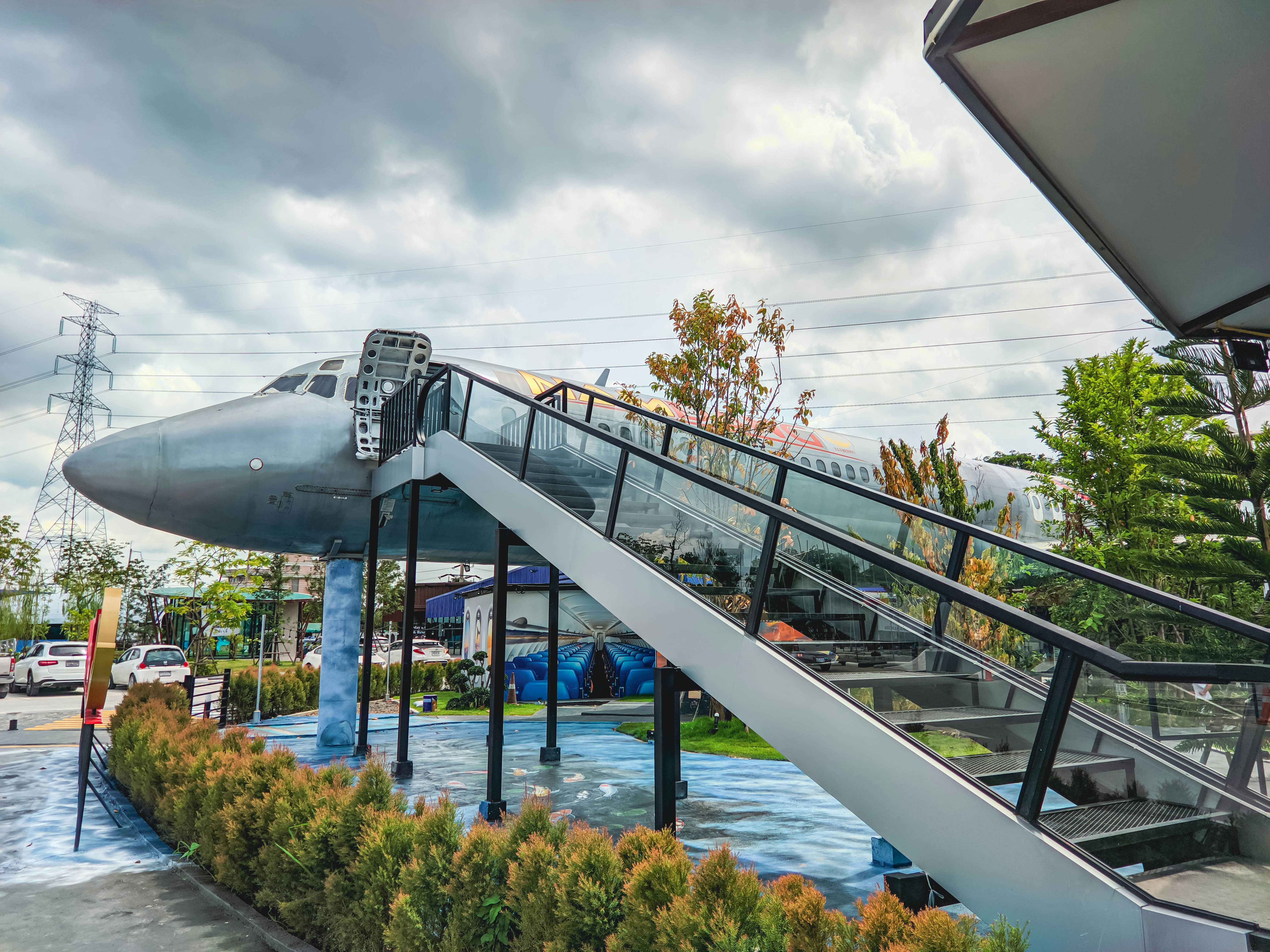 Decommissioned MD-81 aircraft displayed outdoors under a cloudy sky with an access staircase leading to its entrance.