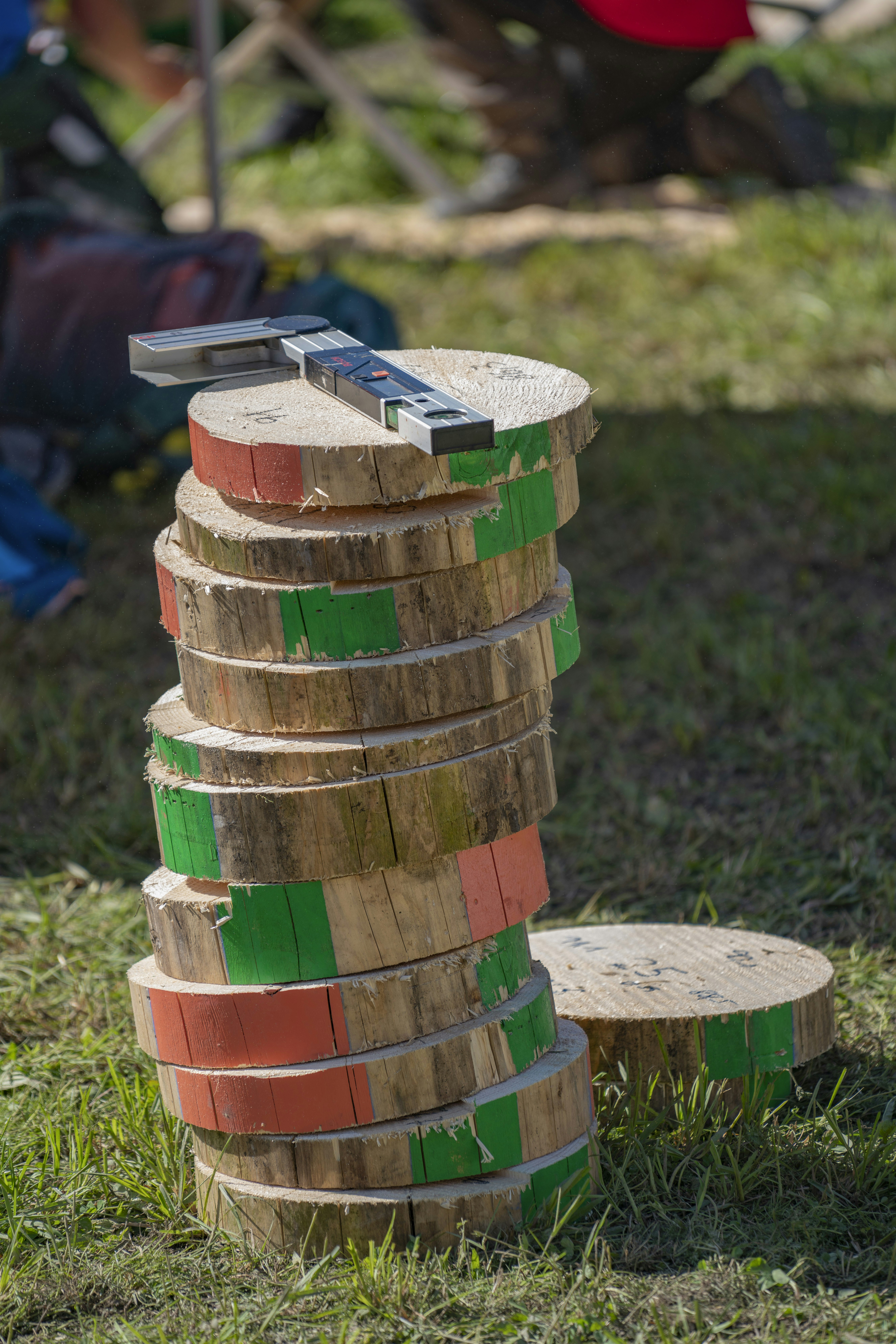 a stack of wooden blocks sitting on top of a grass covered field