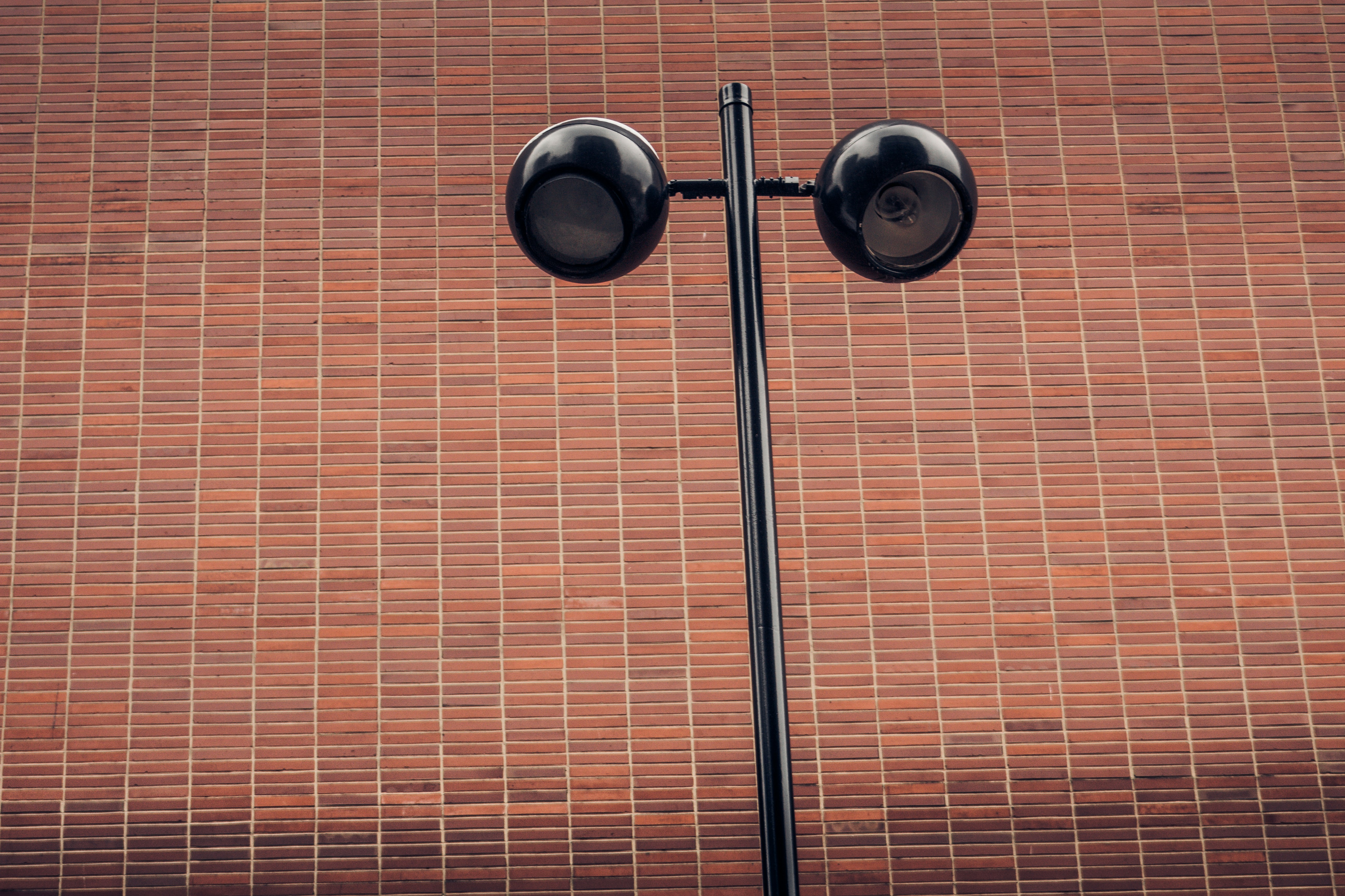Twin Globe Lanterns Framing a Brick Facade