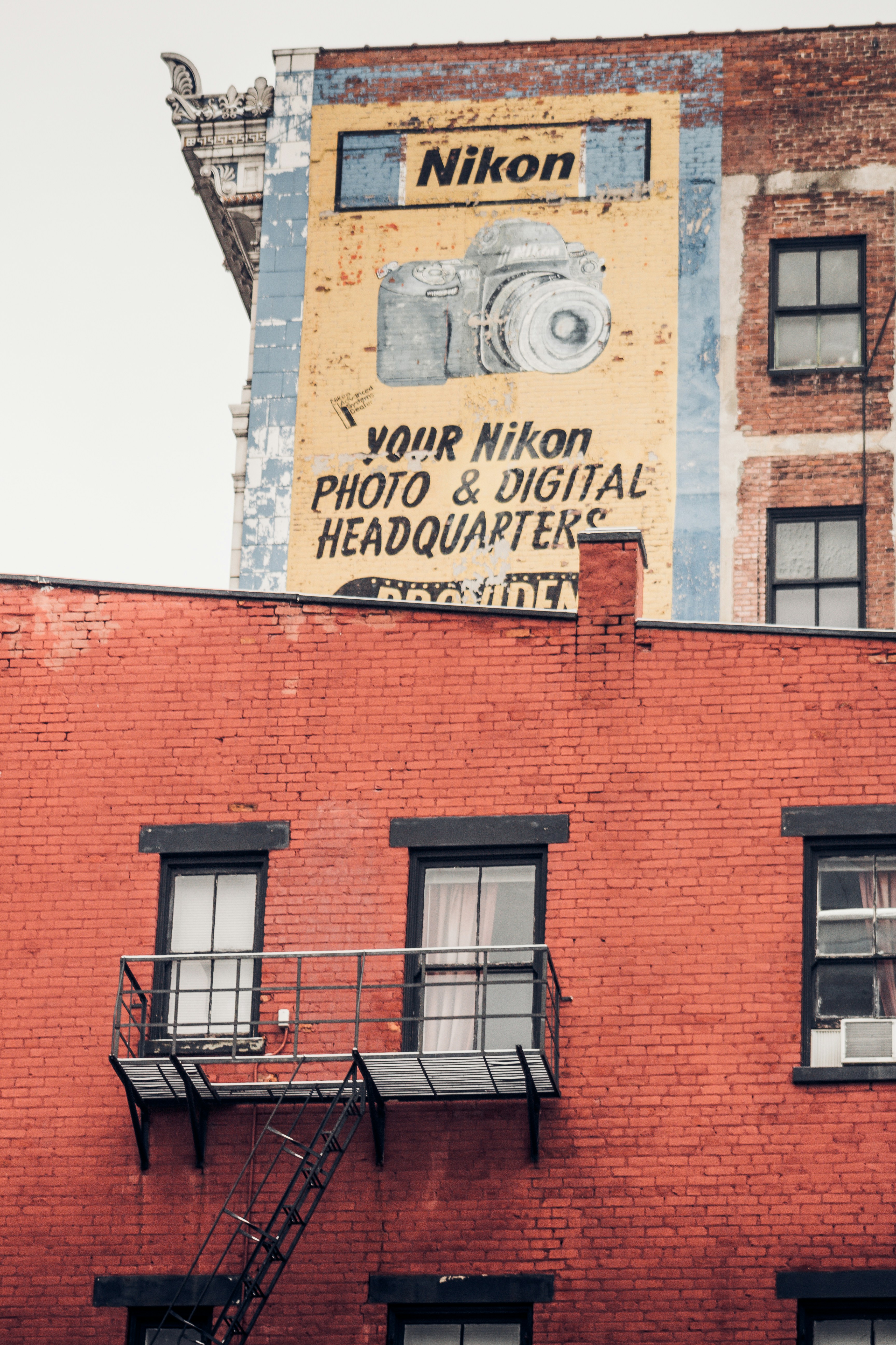 Nikon Sign Above a Weathered Brick City Wall