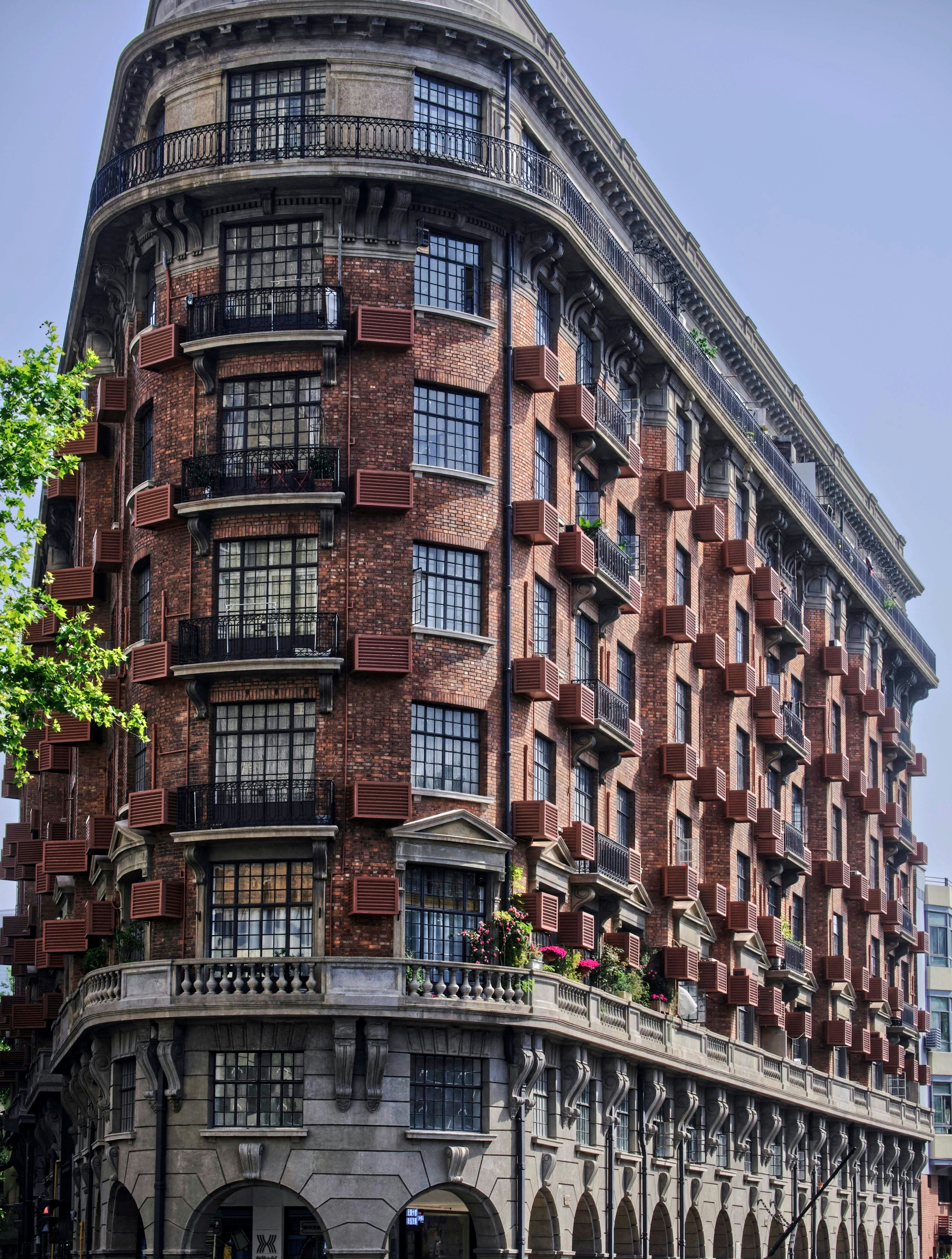 A large brick building with many windows and balconies photo – Free ...