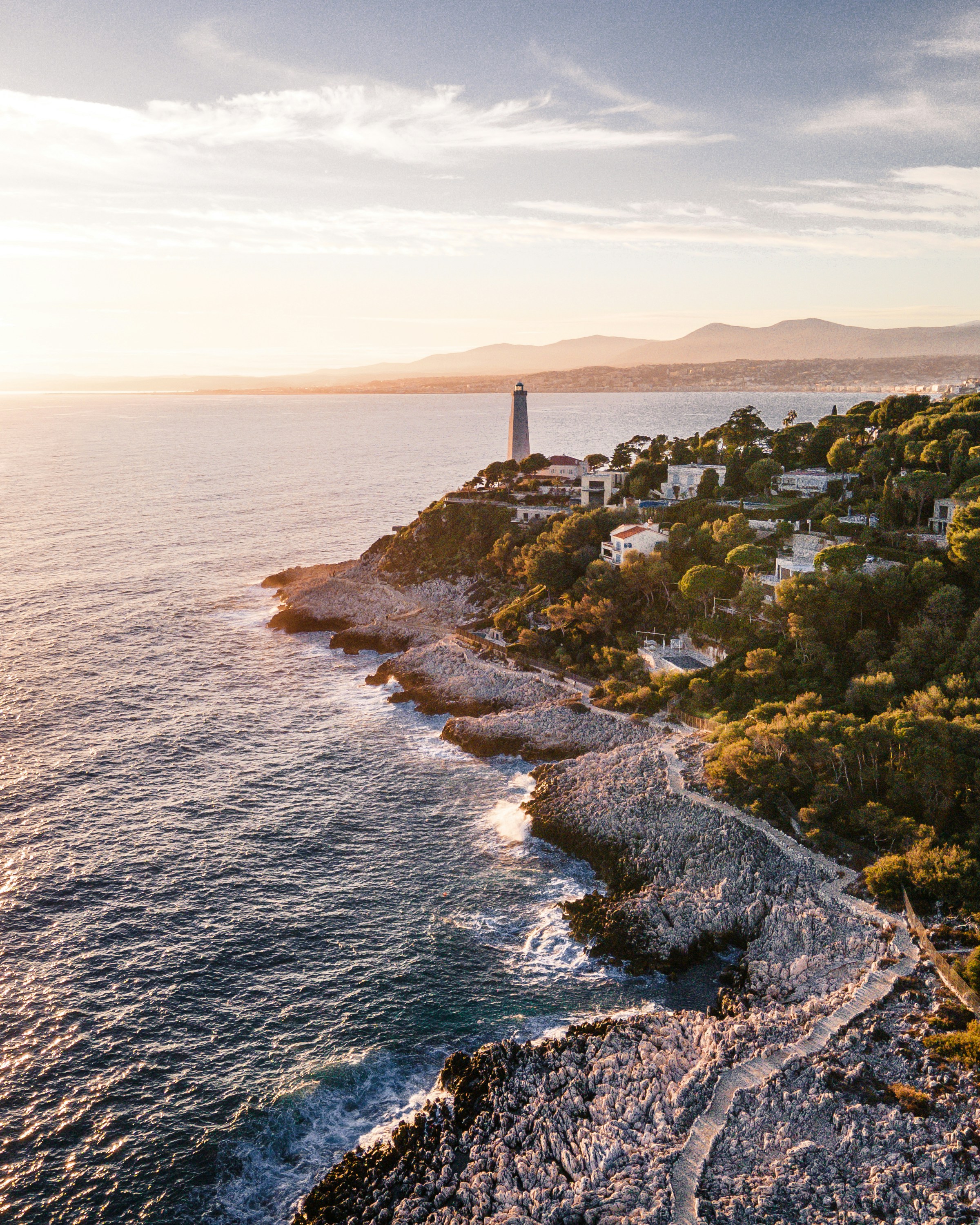 Lighthouse at Golden Promontory: Cliffside Coastline at Sunset