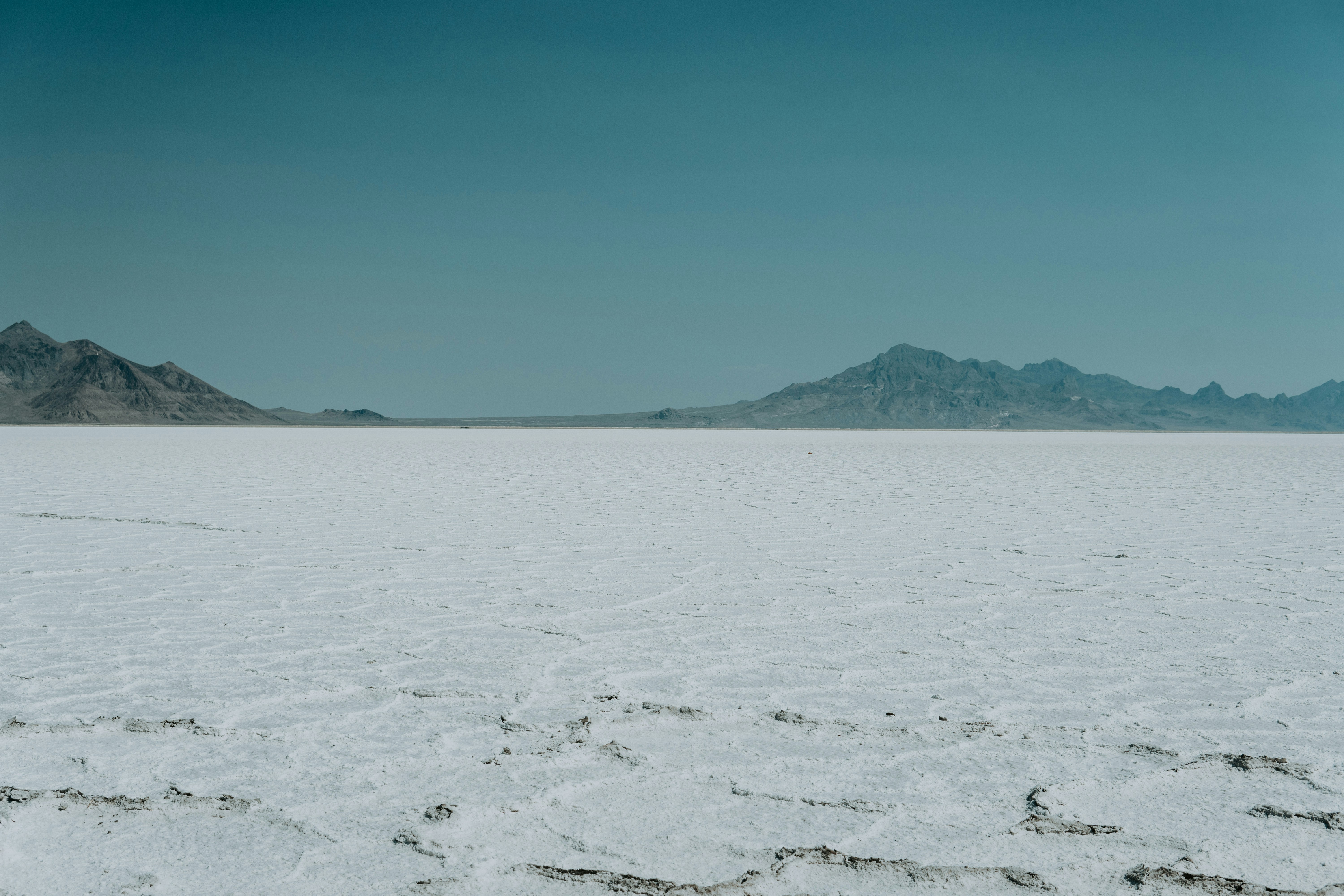 A barren plain with mountains in the distance photo – Free Backgrounds ...