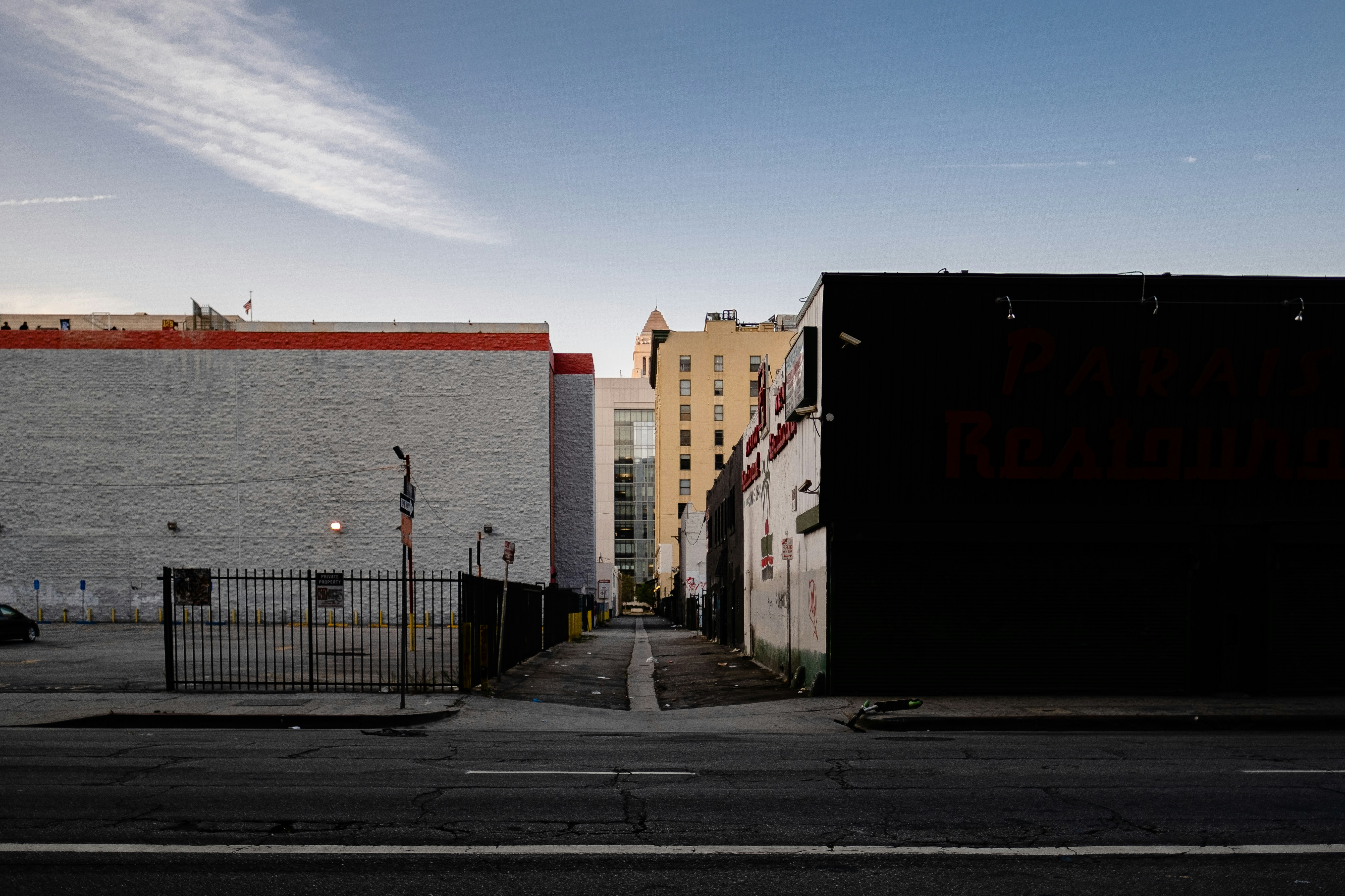 Narrow alley framed by stark, contrasting buildings, evoking a sense of solitude in the urban landscape.