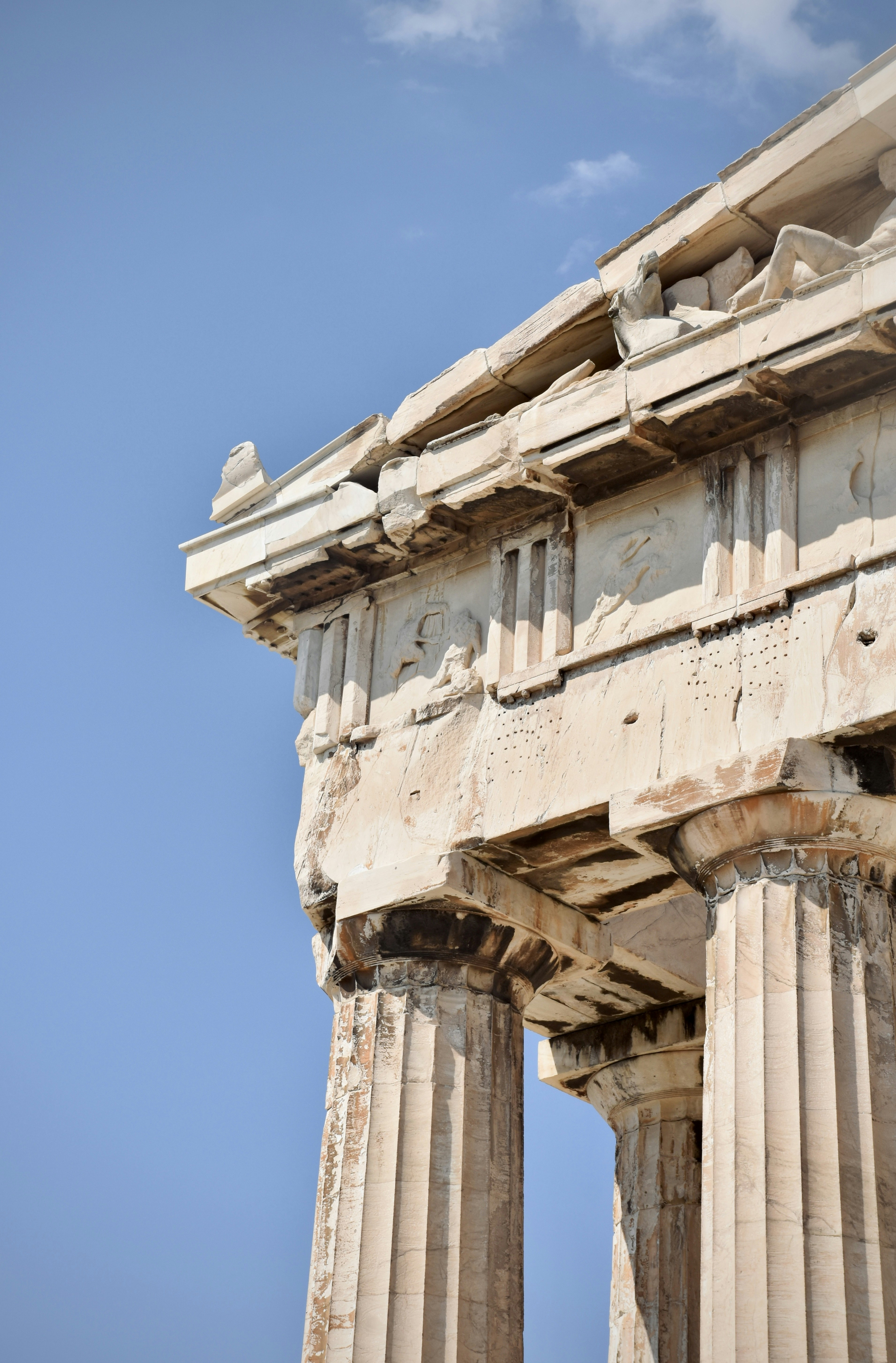 Details of the Partenon temple on the Athens Akropolis. | a tall stone structure with many columns