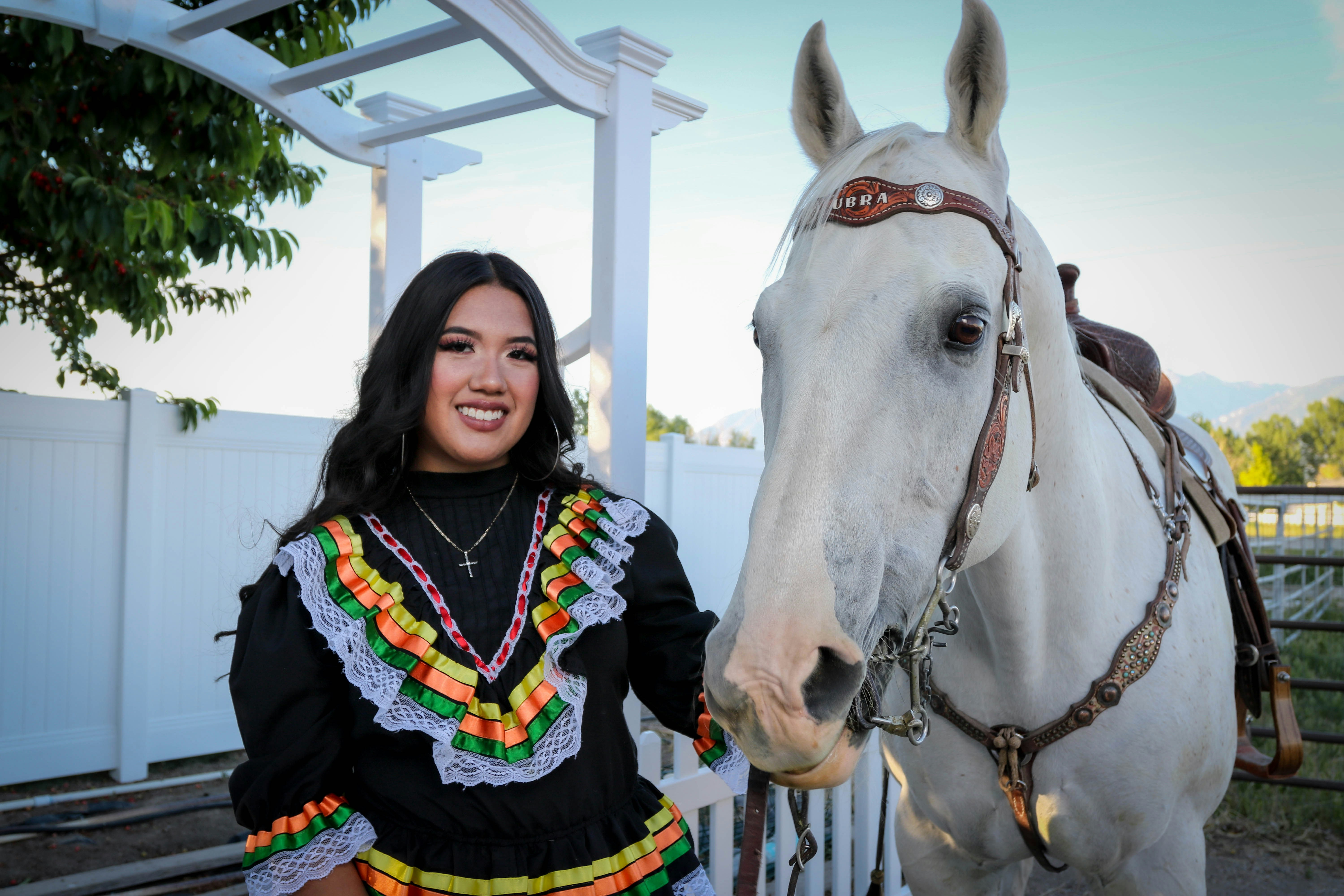 a woman standing next to a white horse