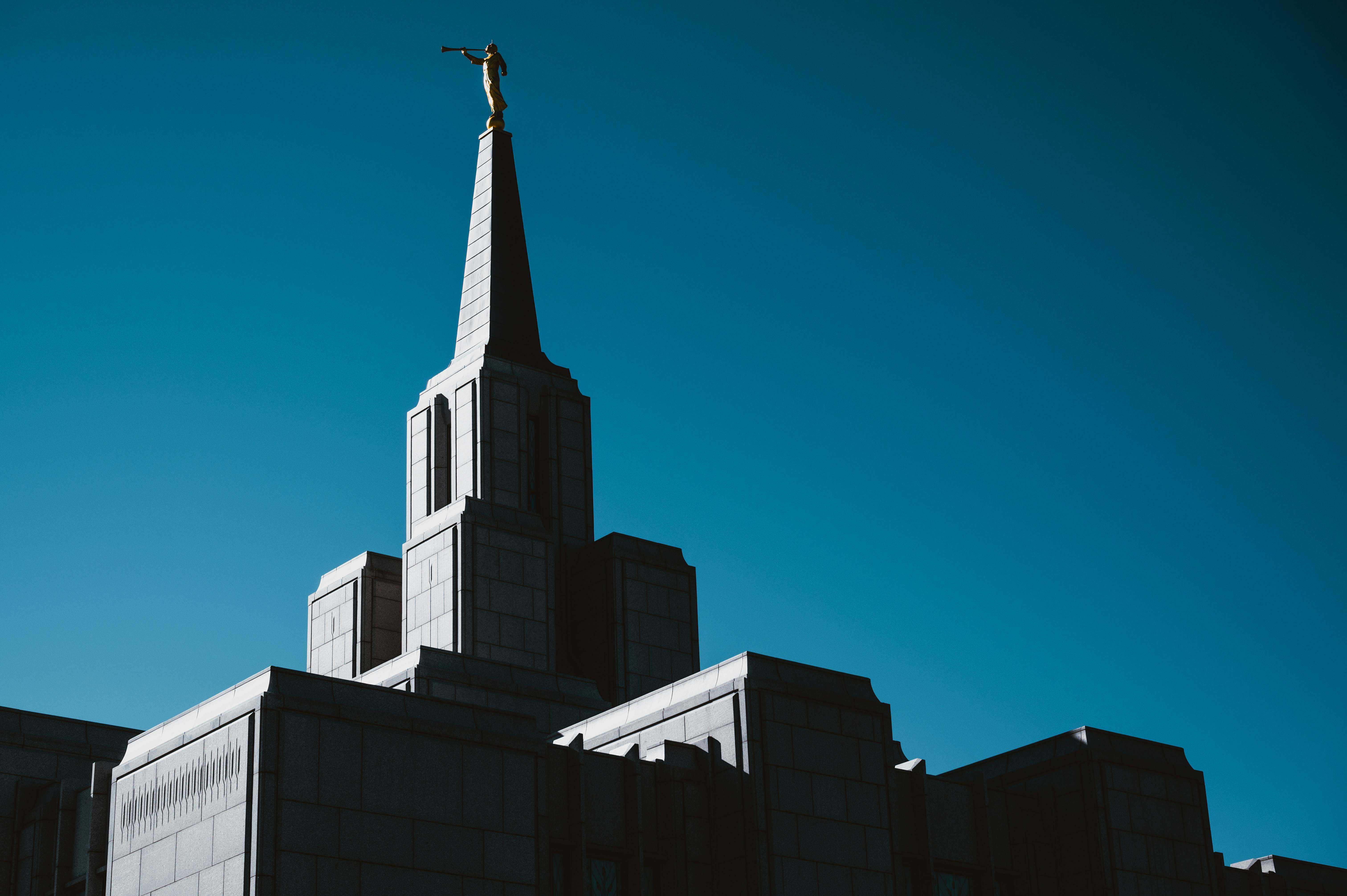Statue atop a Stone Spire Framed by a Pristine Blue Sky
