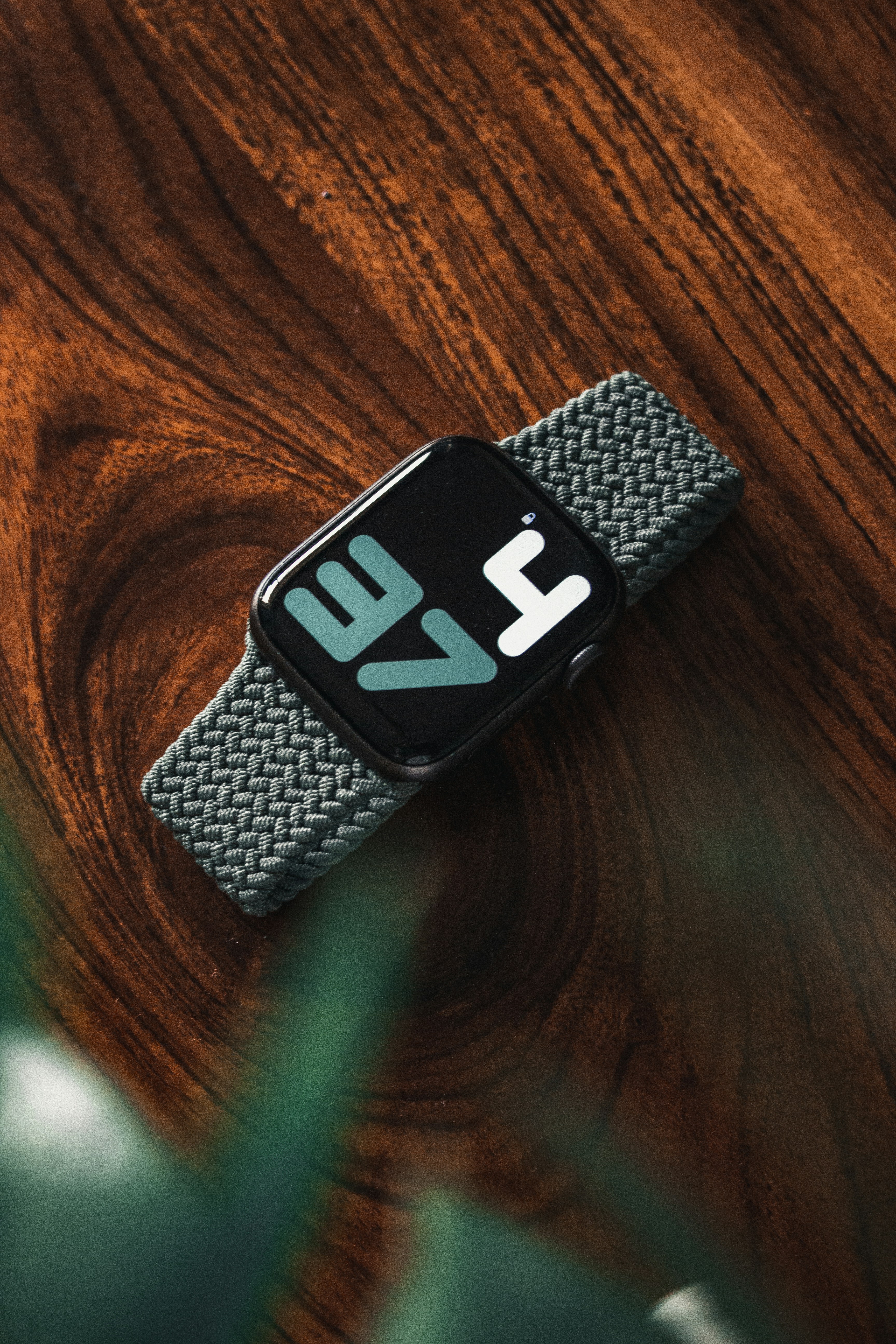 Mystic Timekeeper: A Knit-Washed Apple Watch Resting on Wooden Grain