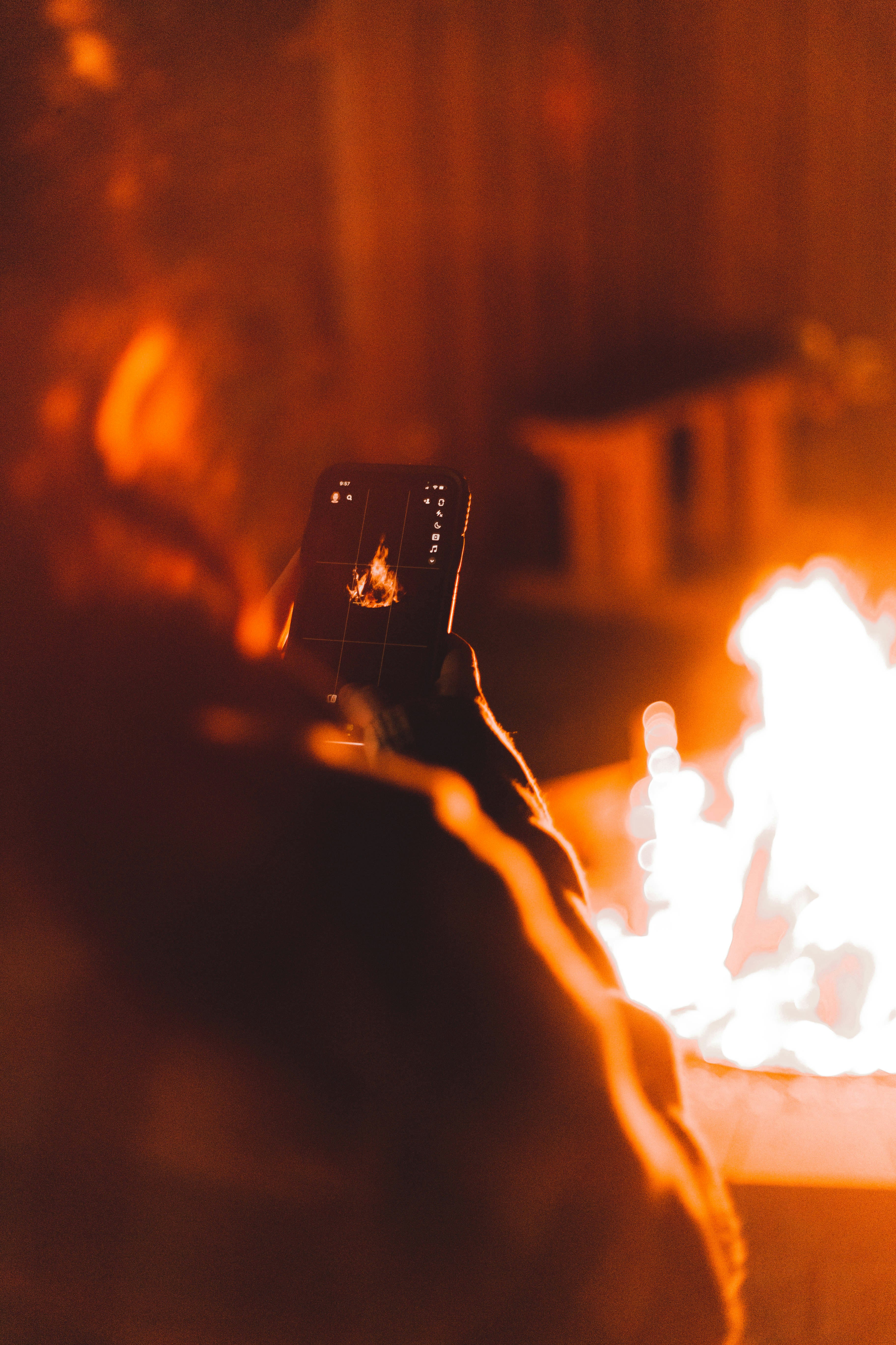 Phone-held Firelight: A Silhouette Captures the Night’s Ember