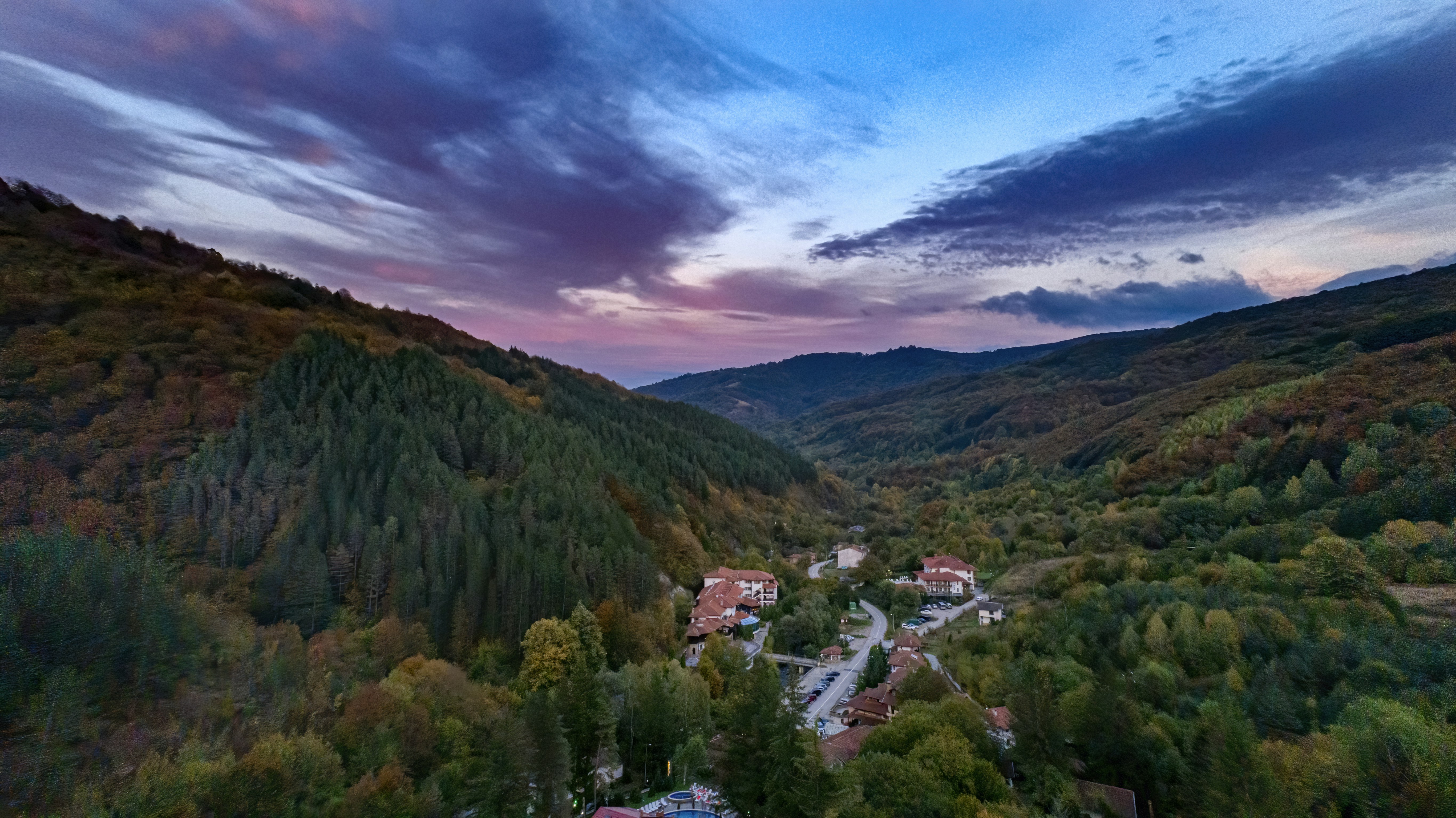 Dusk Over Verdant Valleys: A Village Nestled in Twilight Hills