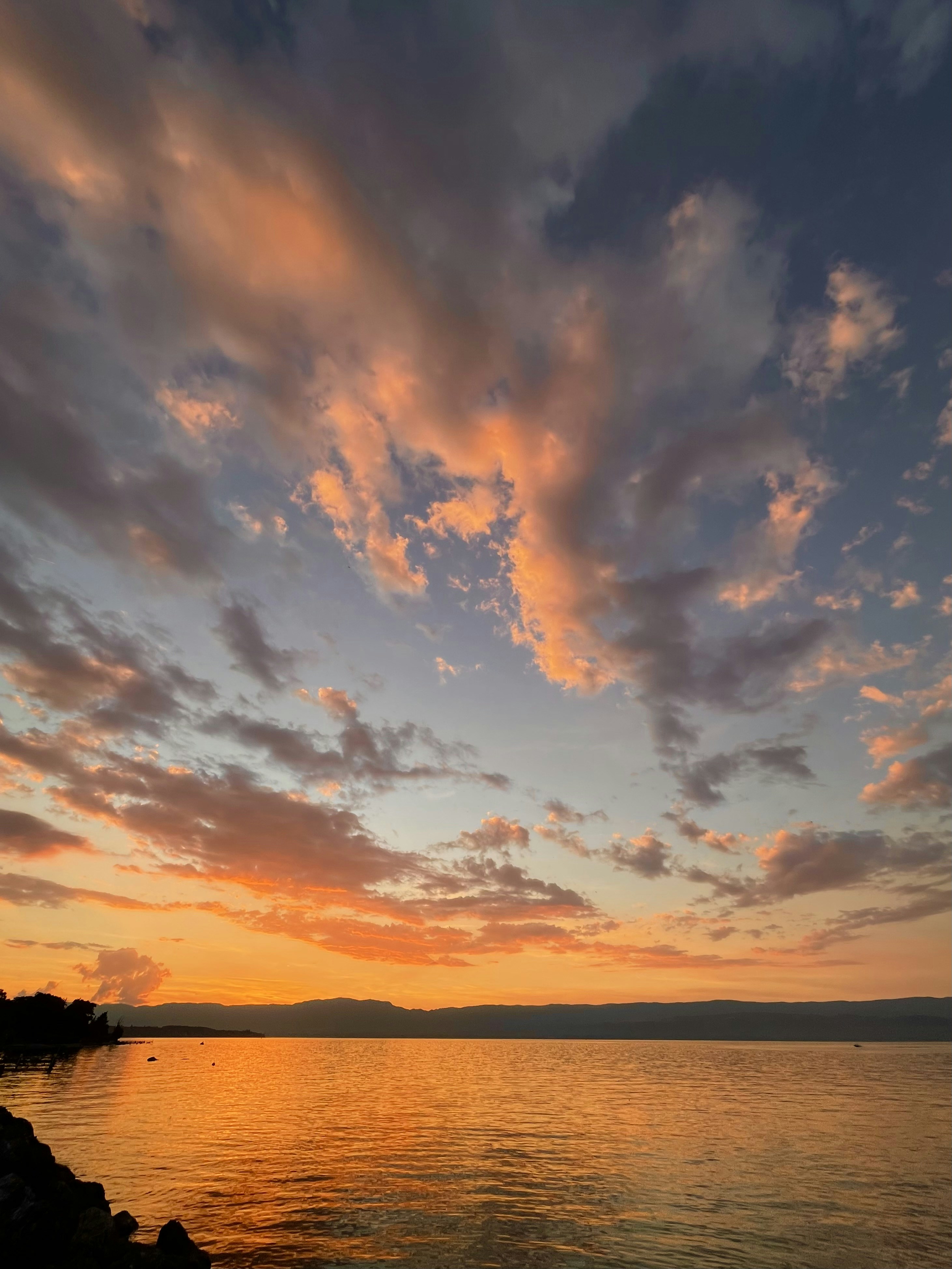 The sun is setting over the ocean with clouds in the sky photo – Free ...