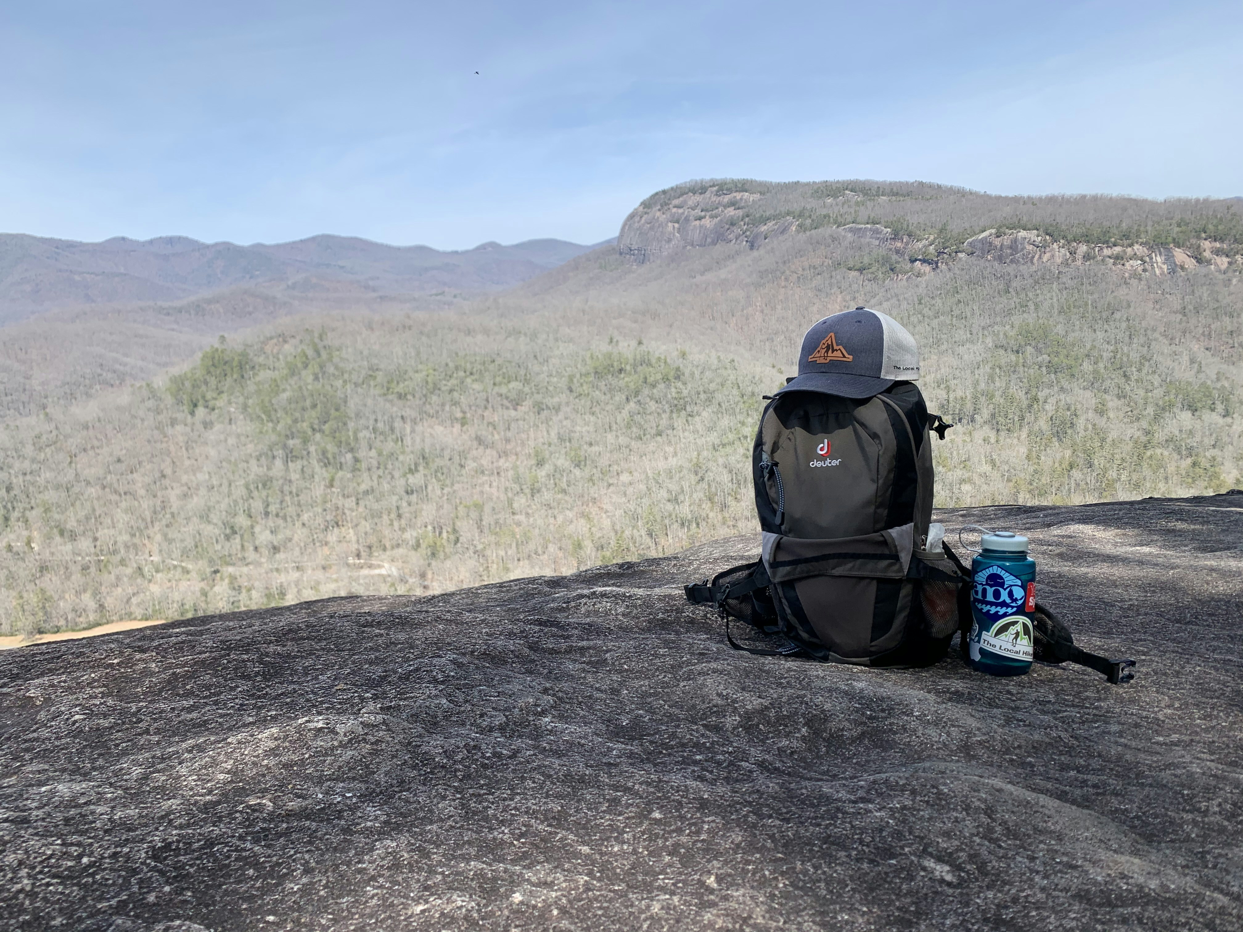 A backpack sitting on top of a rock next to a can of soda photo – Free ...