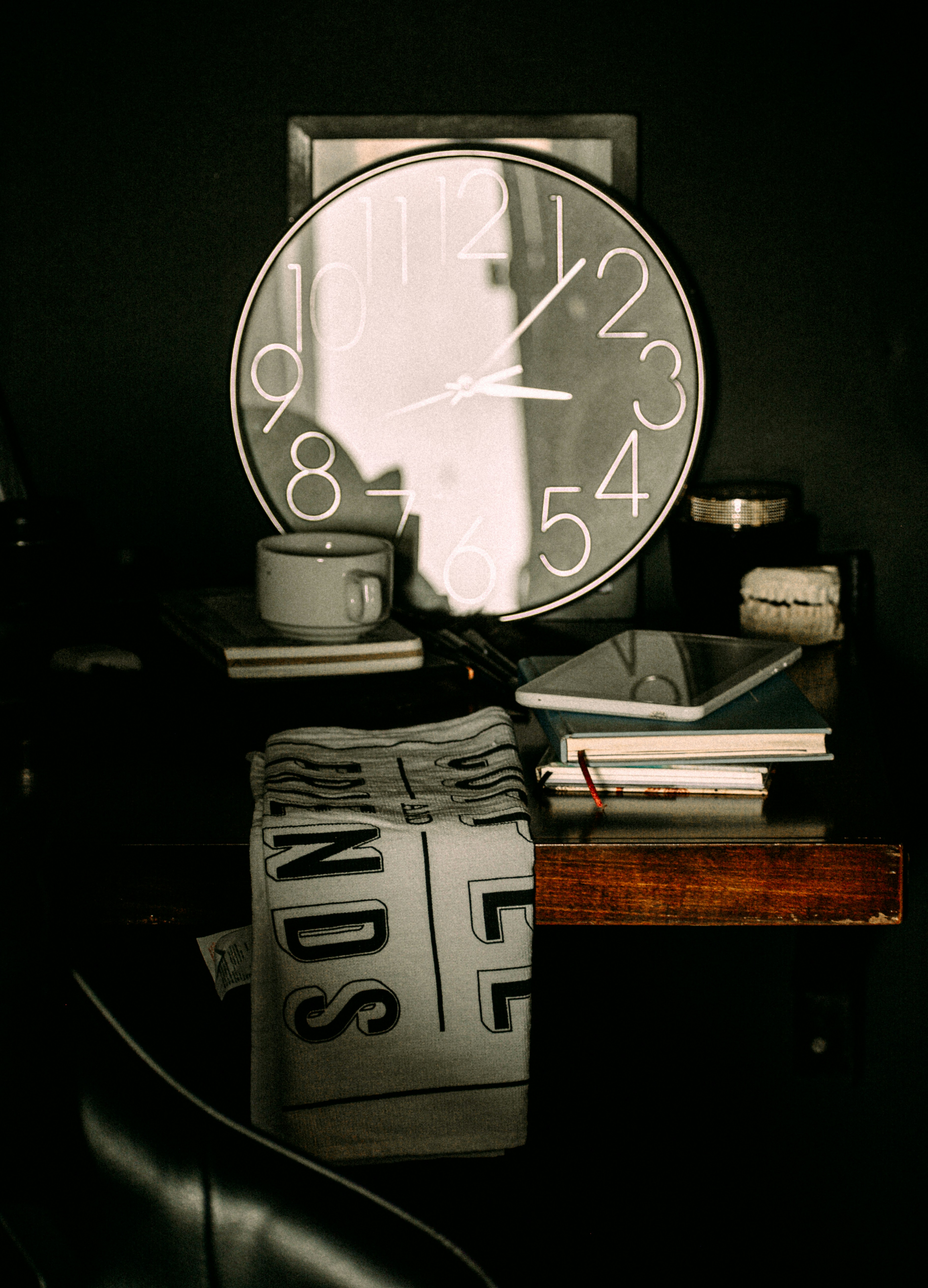 a clock sitting on top of a wooden table