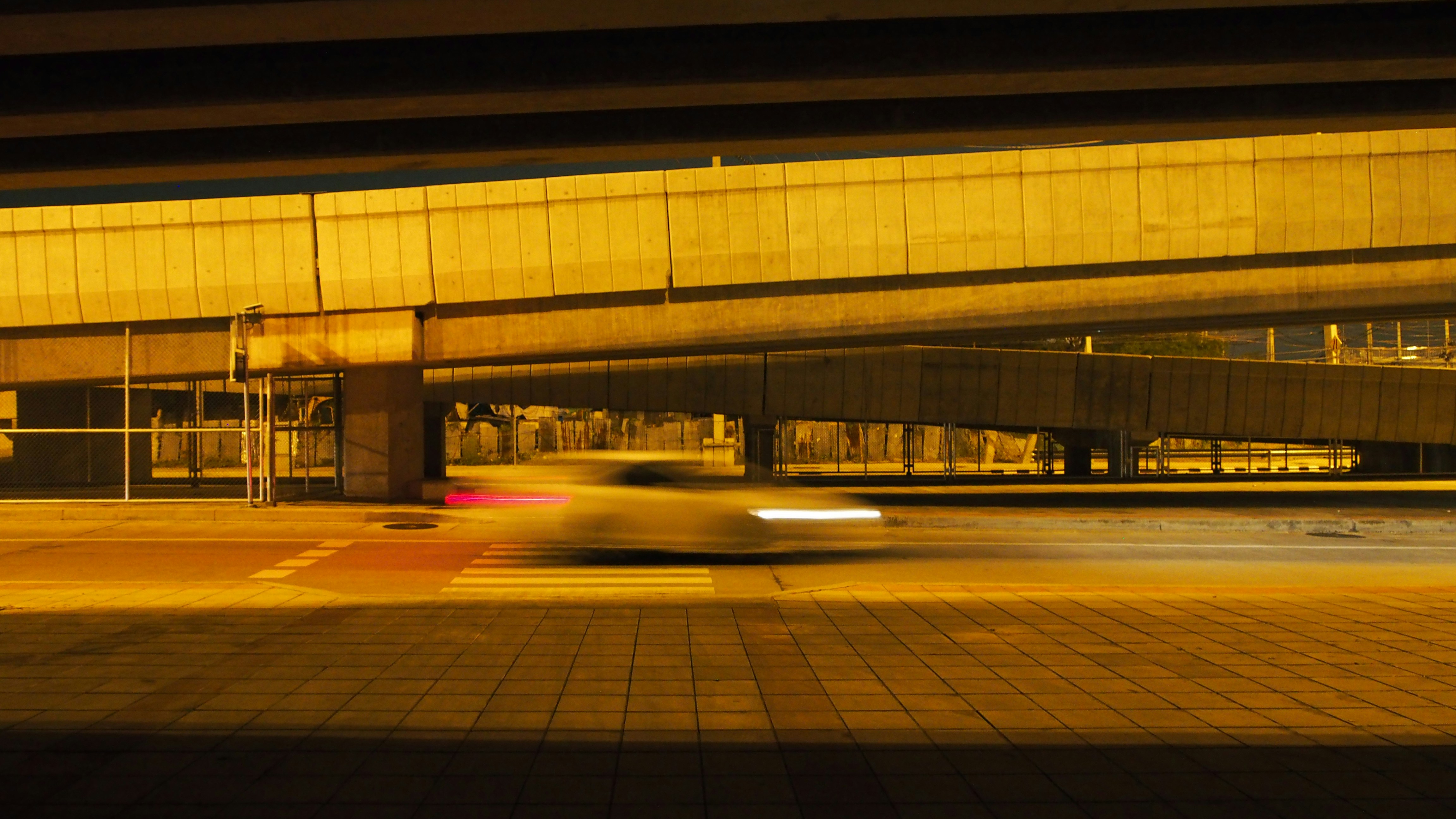 A blurry picture of a car driving under a bridge photo – Free Car Image ...