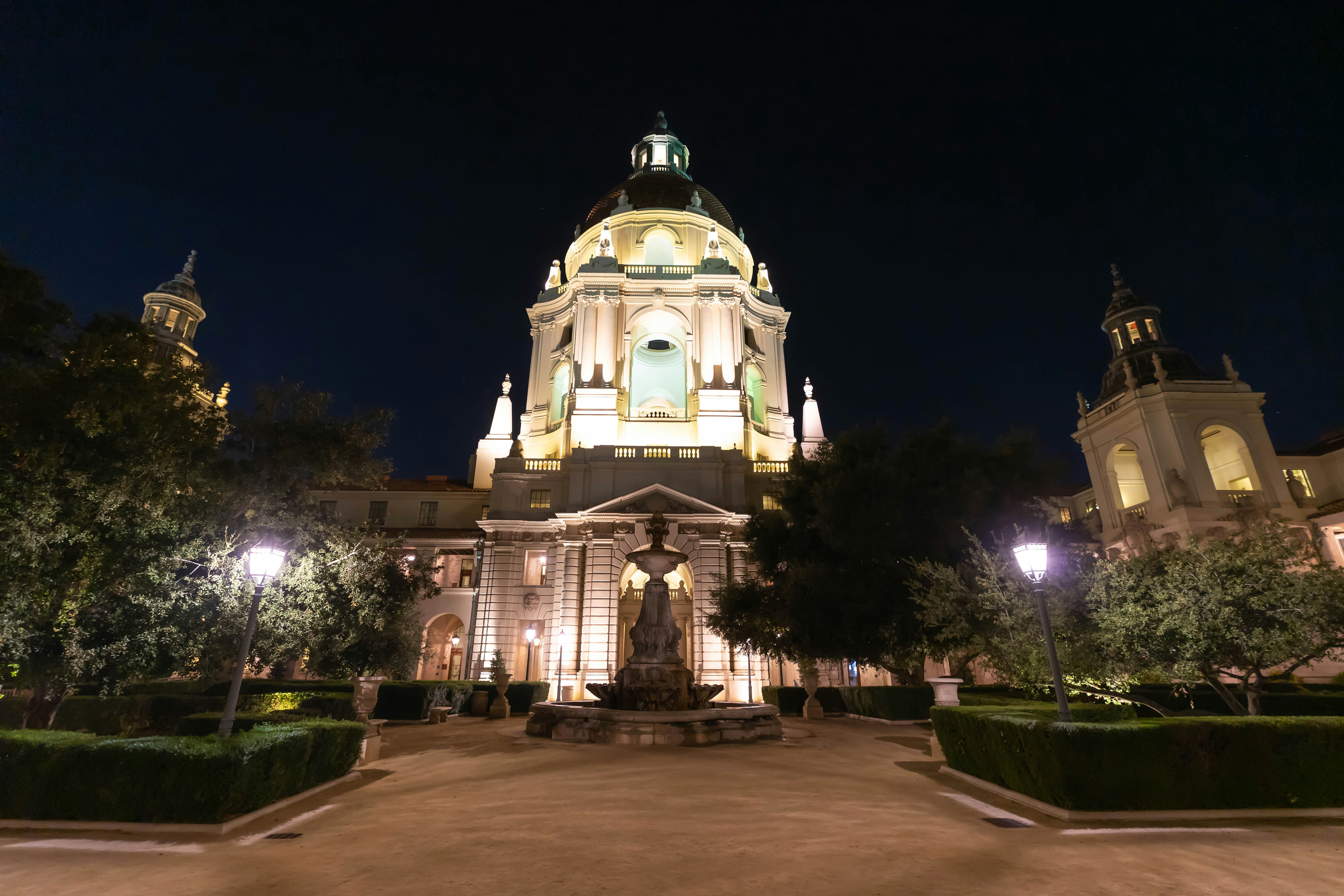 Grand building with a domed roof and illuminated facade set against a night sky.