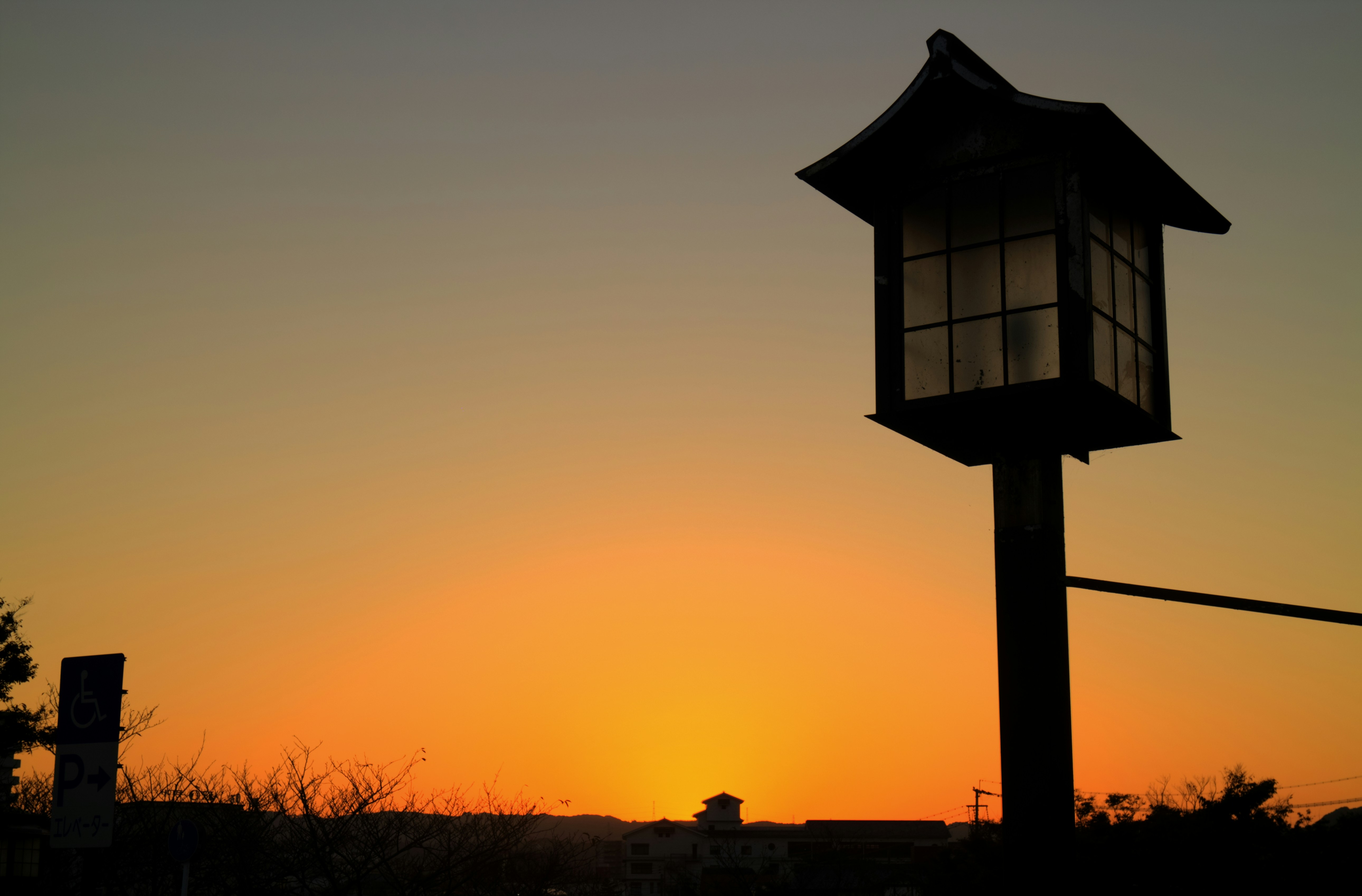 Silhouette at Dusk: A Lantern Against the Golden Horizon