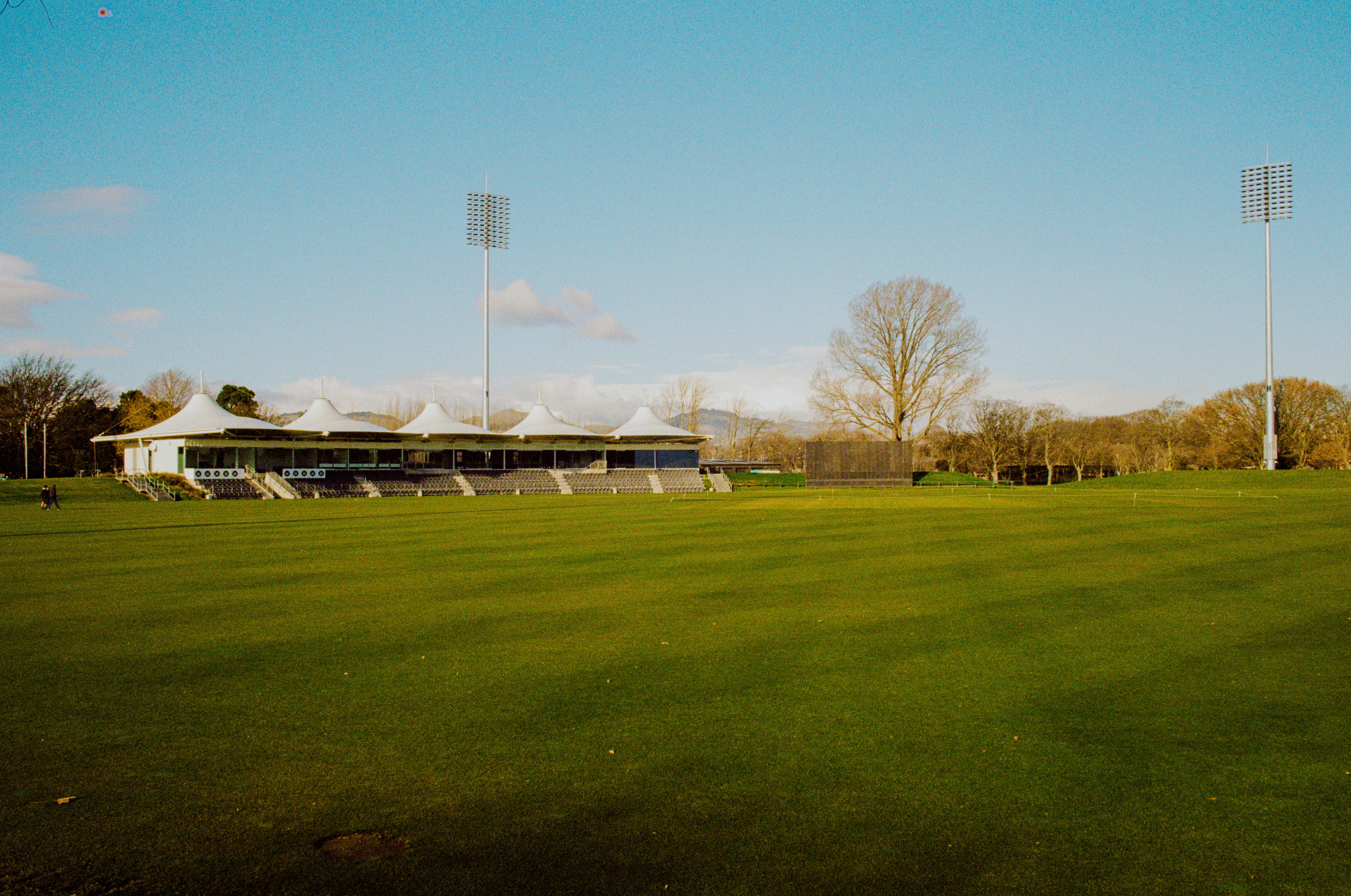 A baseball field with a large white building in the background photo ...
