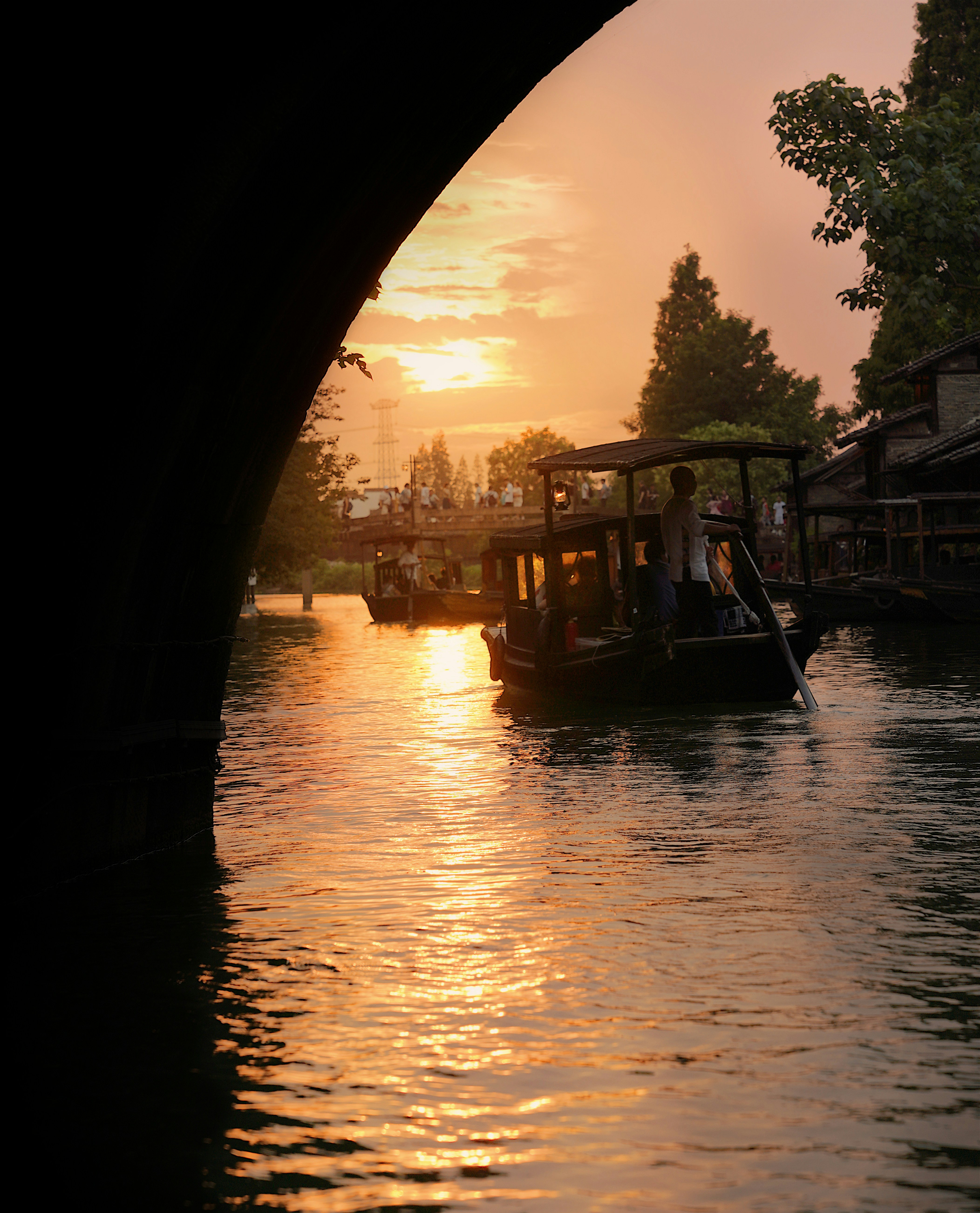 A couple of boats floating down a river under a bridge photo – Free ...
