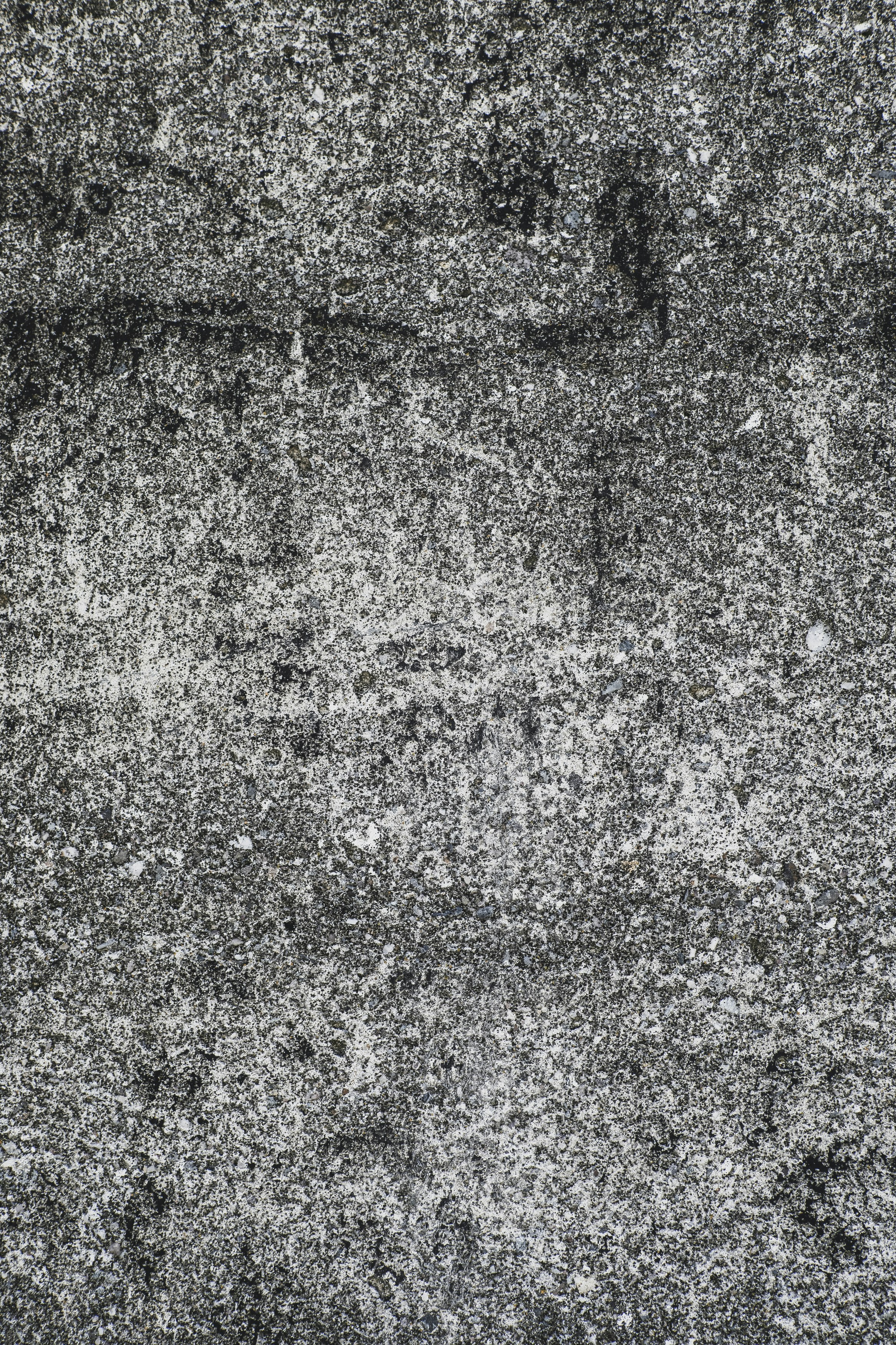 Close-up of a weathered concrete surface showcasing intricate textures and patterns formed over time.