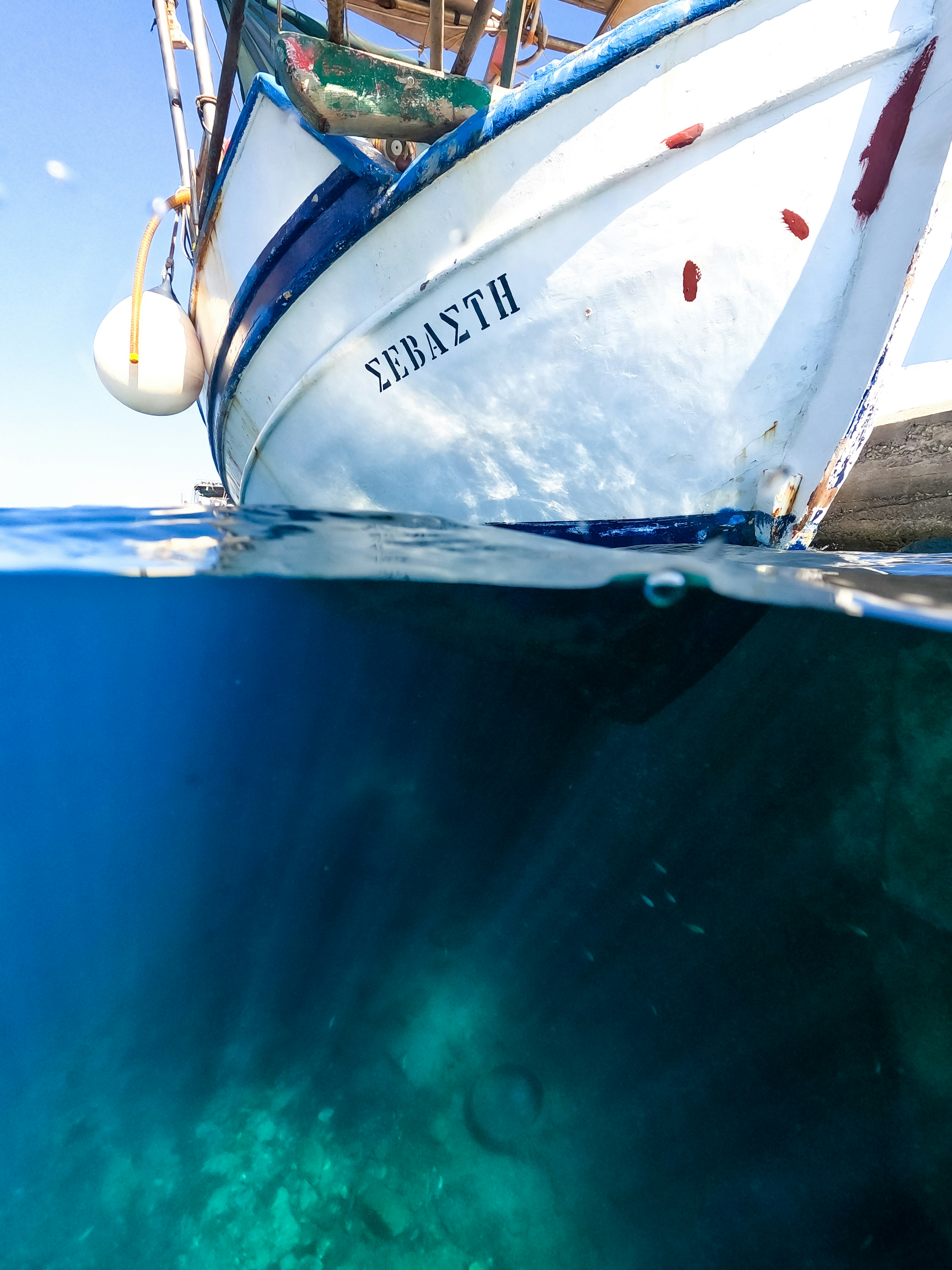 Waterline Portrait: A Sailboat Halved by Ocean Clarity