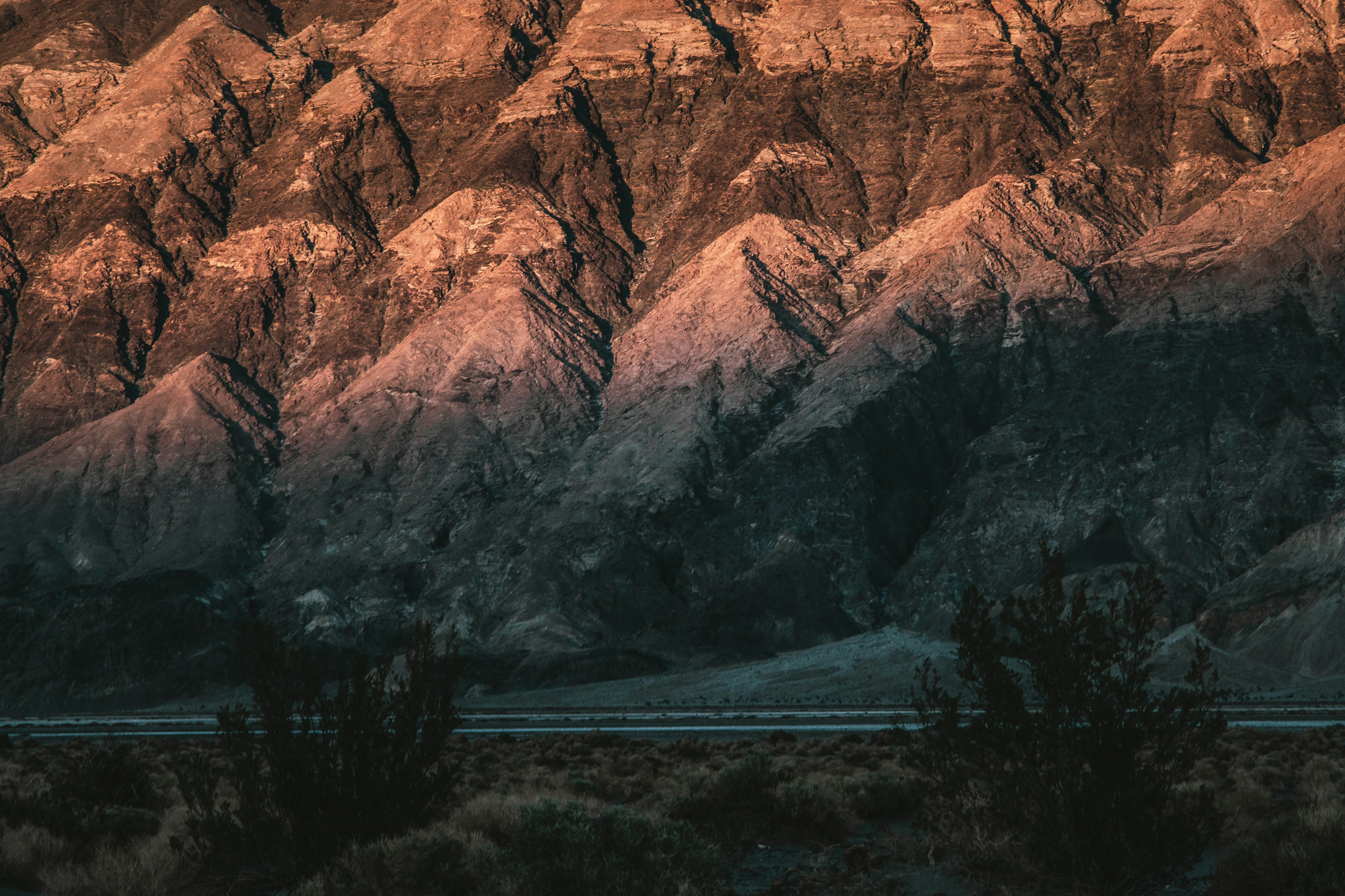 a mountain range with a train on the tracks in the foreground