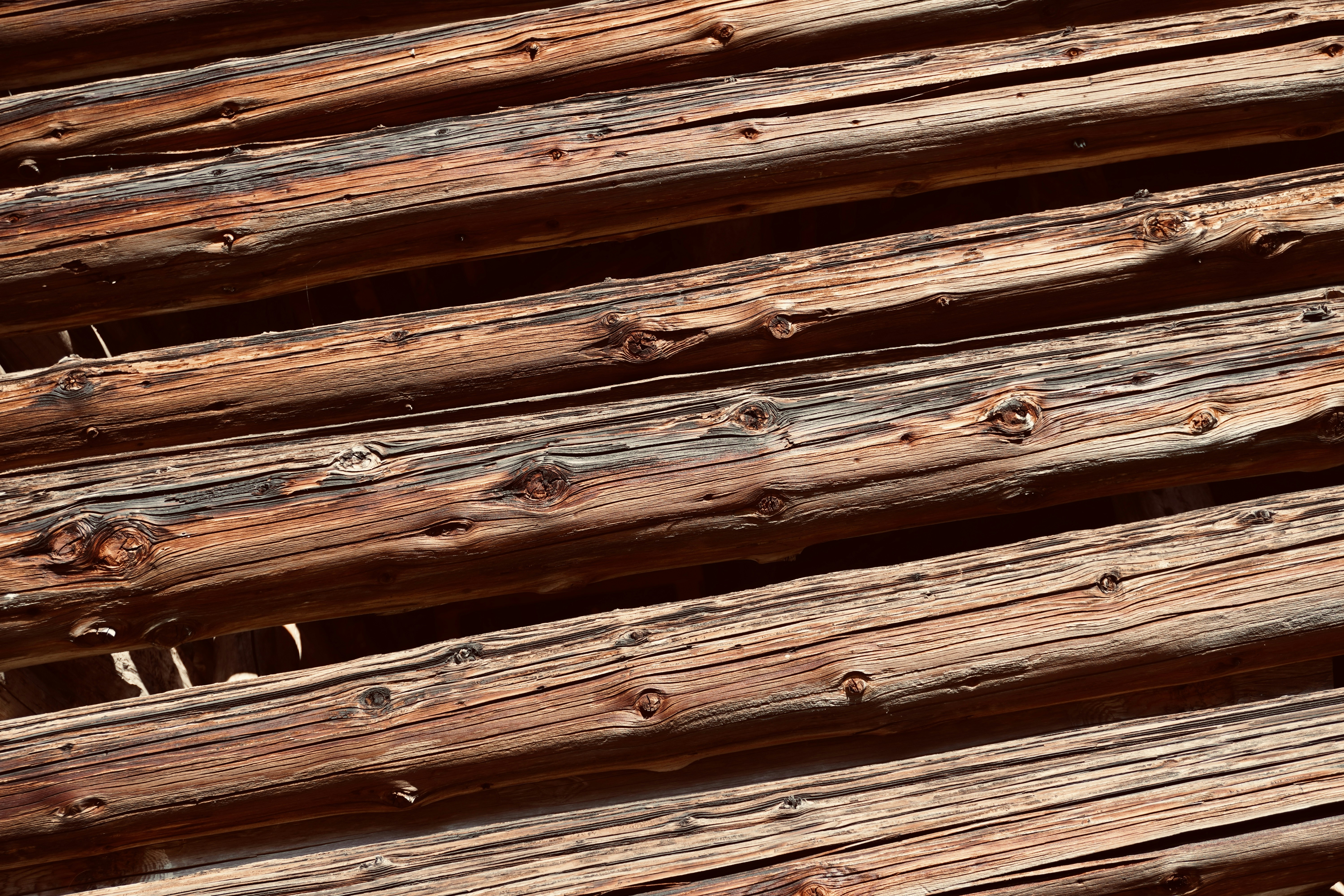 Close-up of weathered wooden beams showcasing intricate textures and natural patterns. The image highlights the beauty of aged timber.