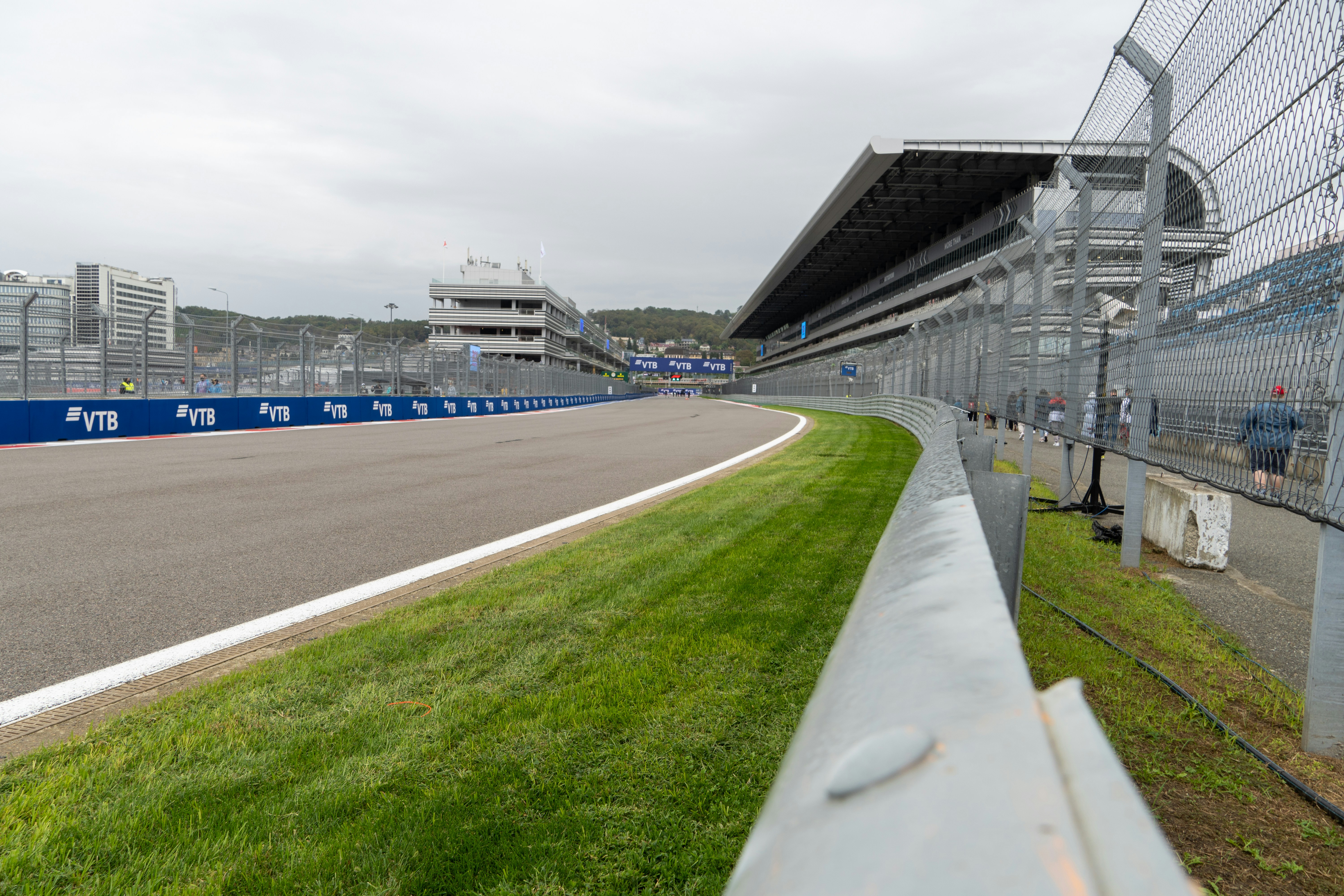 A race track with grass and a building in the background photo – Free ...