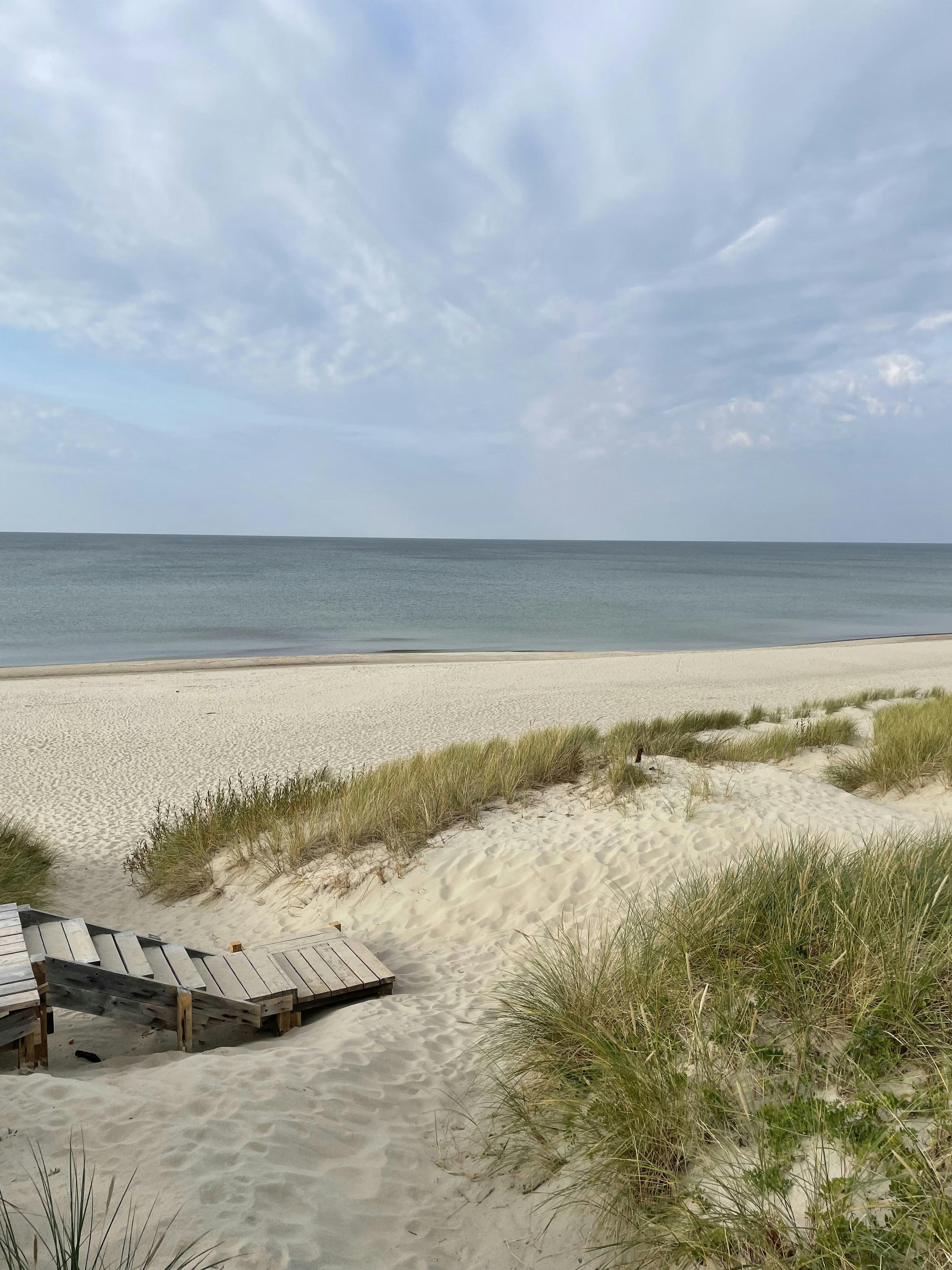 a sandy beach with a few chairs on it