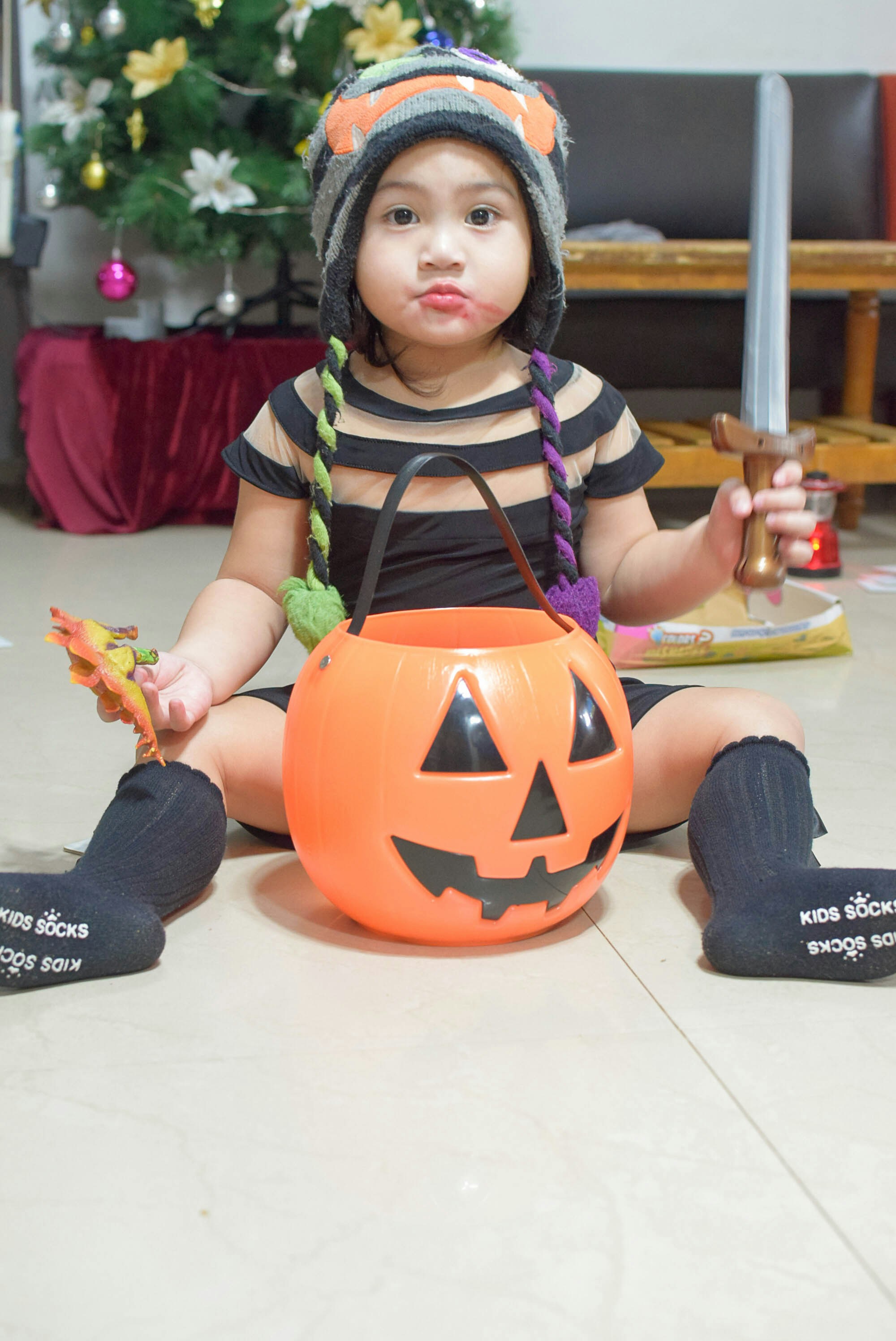 Playful Halloween Standoff: Little Pirate Girl with a Glow in the Pumpkin Scene