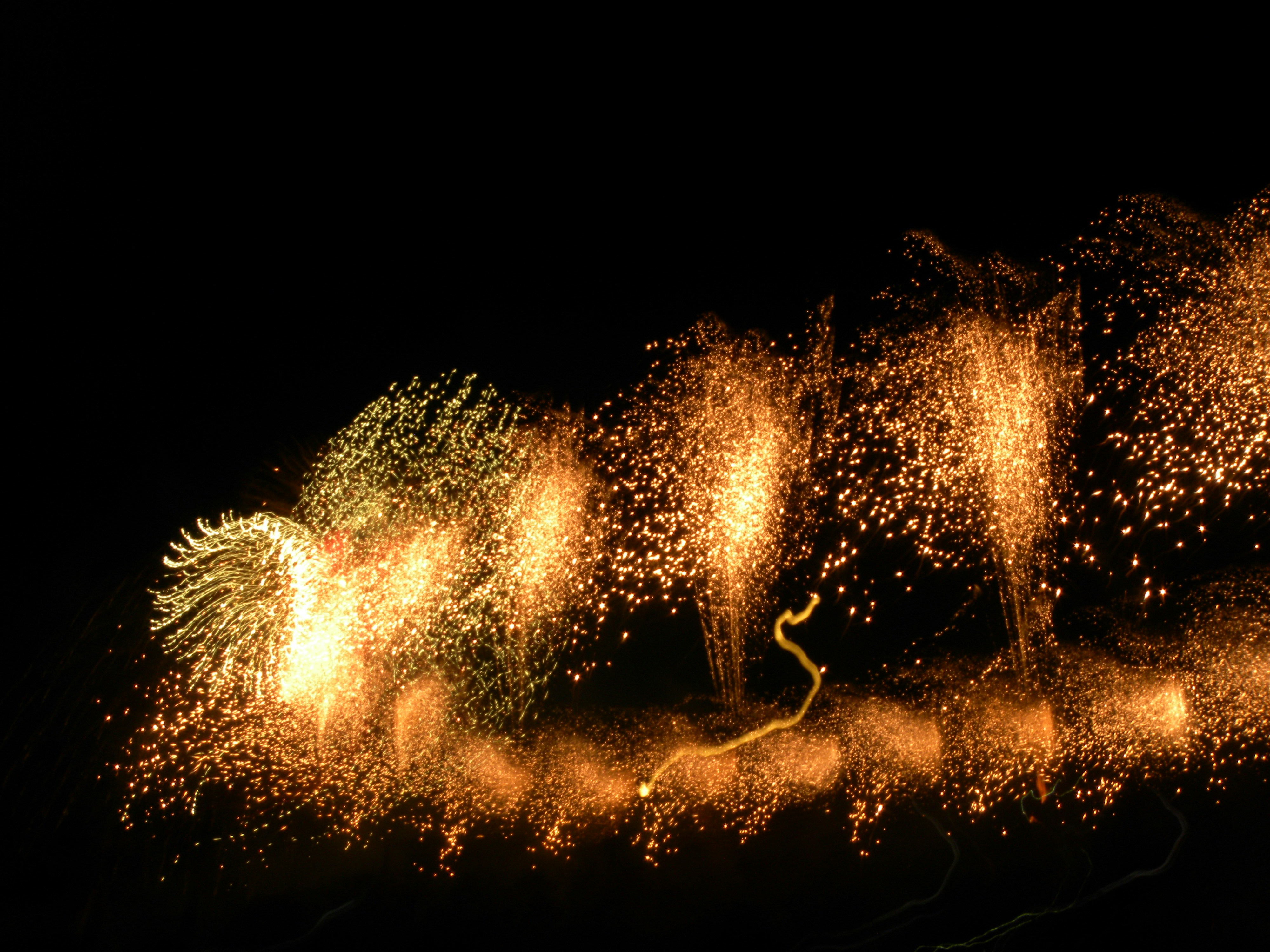 Dynamic display of fireworks bursting in various patterns against a dark backdrop, creating a mesmerizing visual spectacle.
